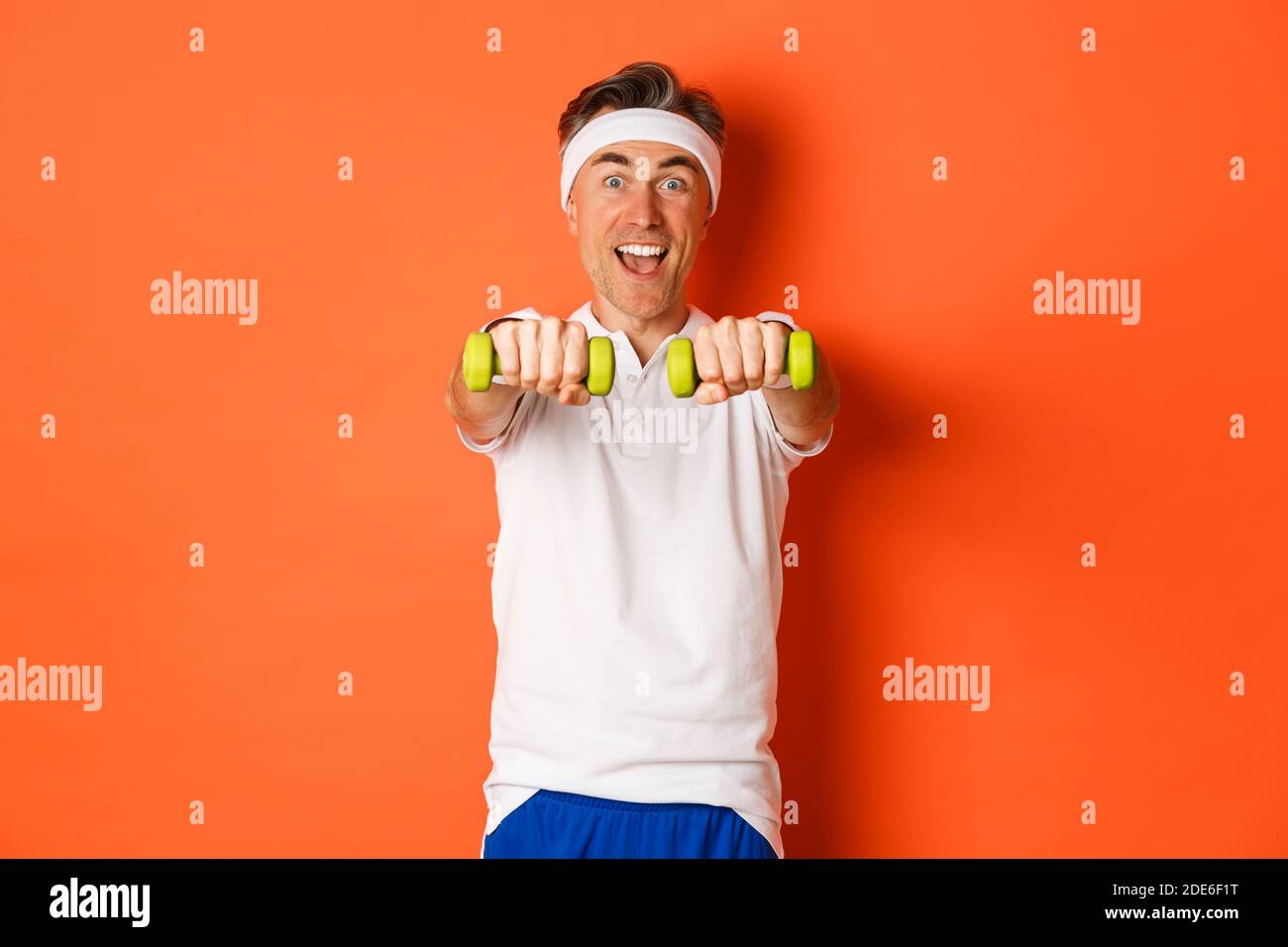 Image of active middle-aged fitness guy, doing sport exercises with ...