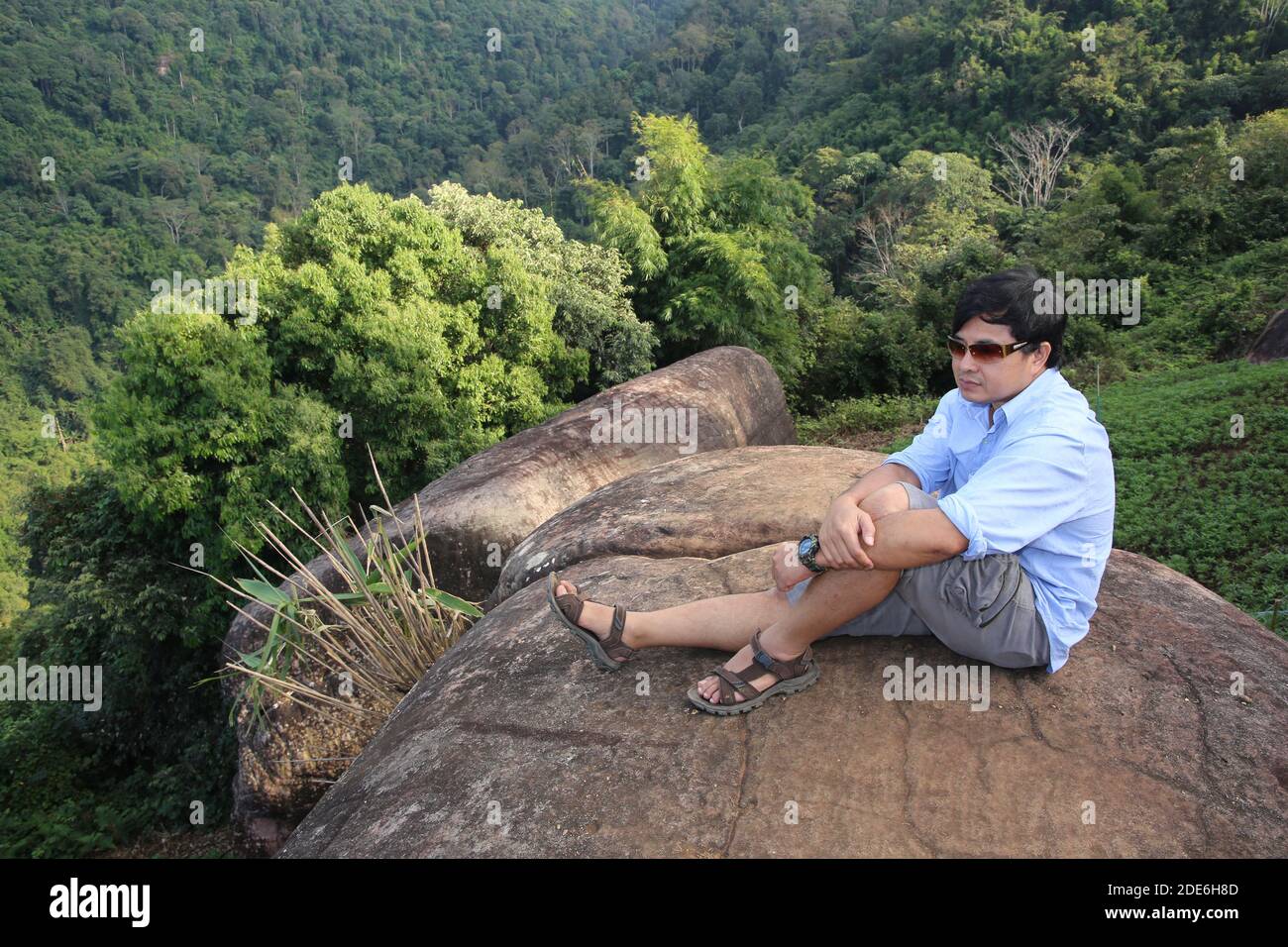 man sitting on stone Stock Photo - Alamy