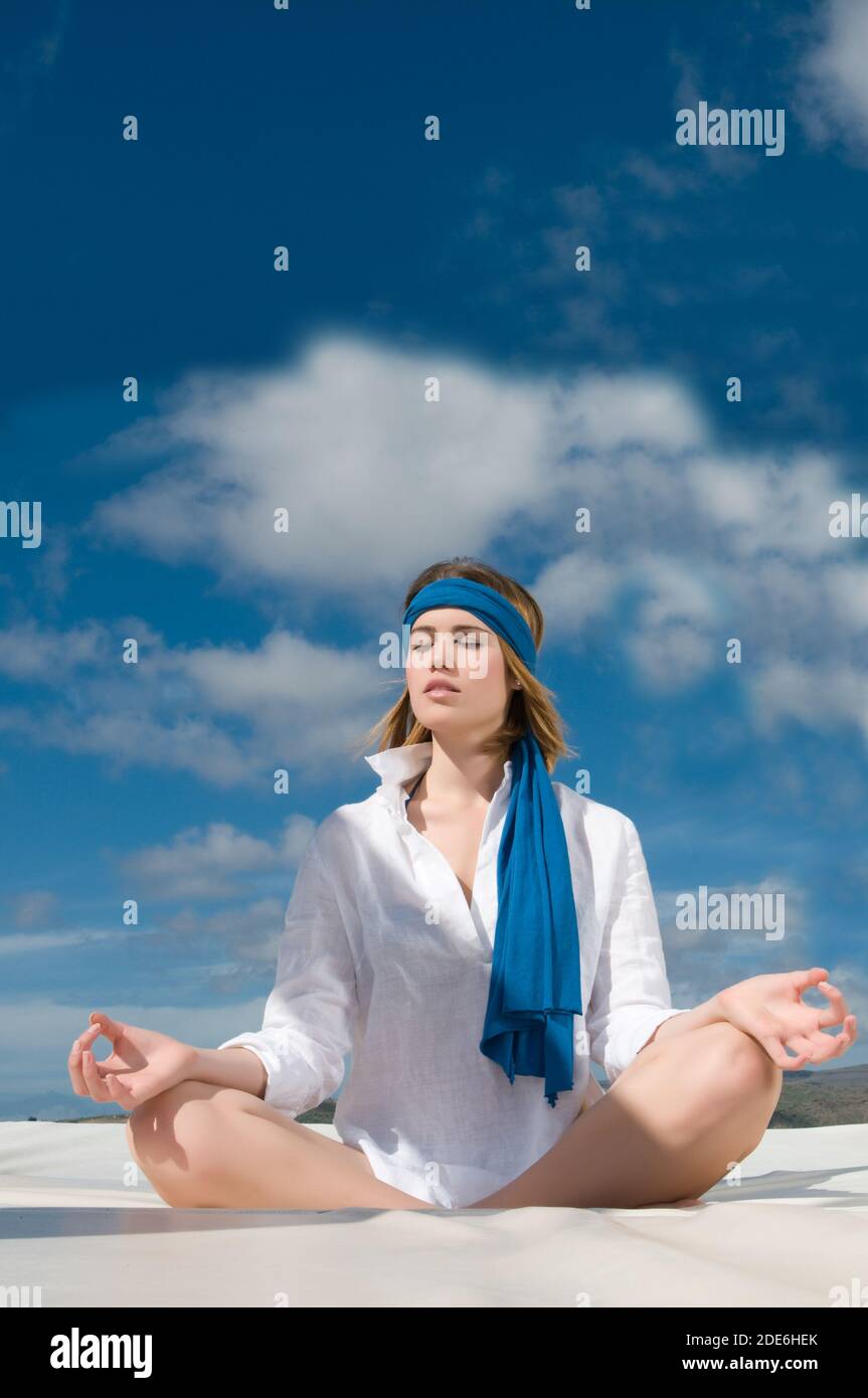 woman meditating on chill out bed under blue summer sky Stock Photo - Alamy