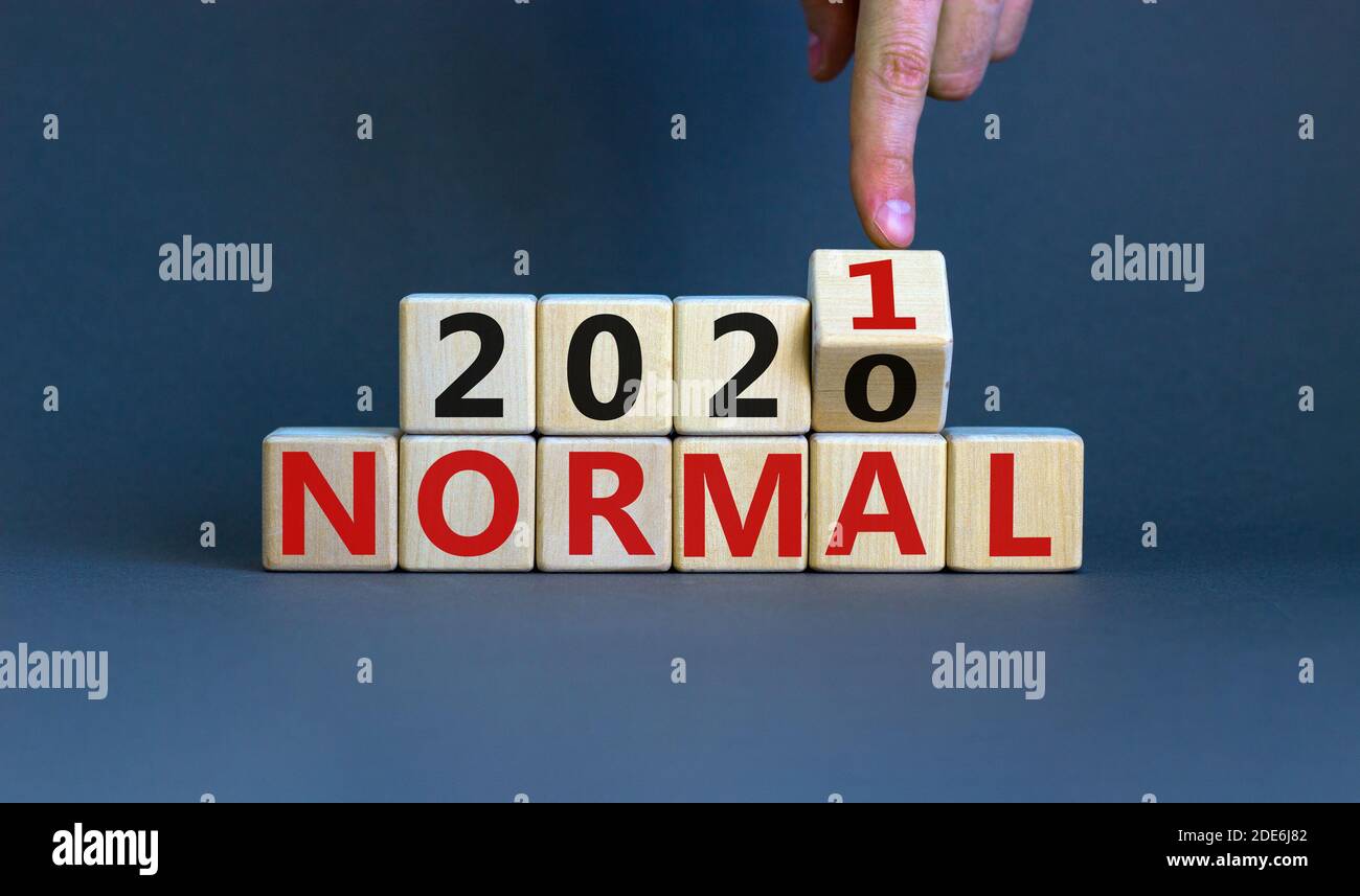 Time to 2021 normal. Male hand turns a cube and changes words '2020 ...