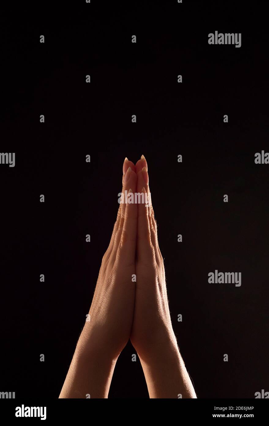 Praying hands in rim lights Stock Photo - Alamy