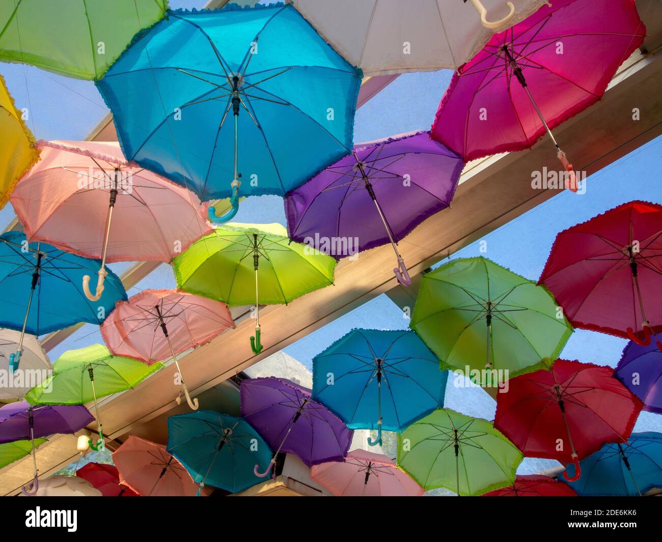 Colored umbrellas hanging between buildings Stock Photo - Alamy