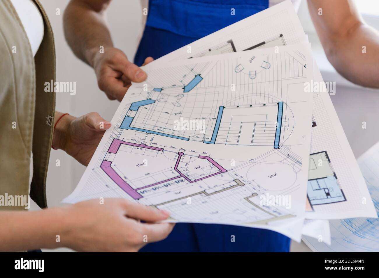The woman holds the layout of the house and shows it to the builders ...