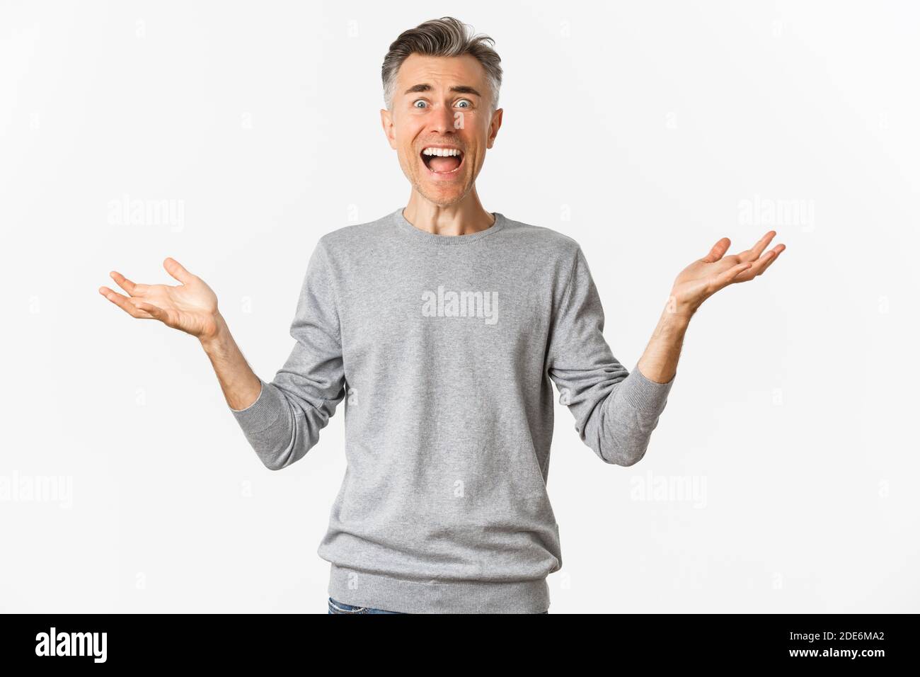 Image of shocked and frustrated man spread hands sideways, shouting and ...