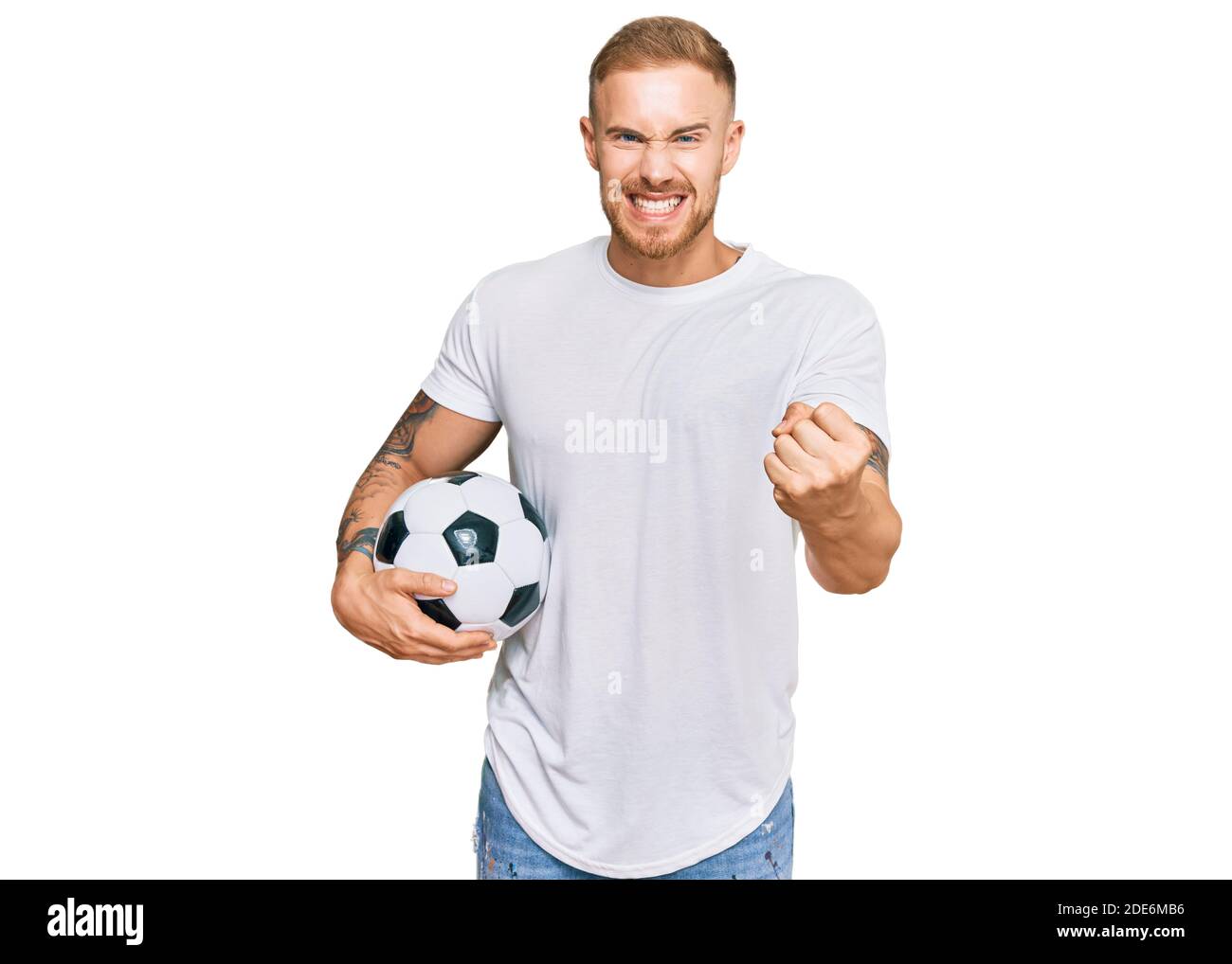 Young irish man holding soccer ball annoyed and frustrated shouting ...