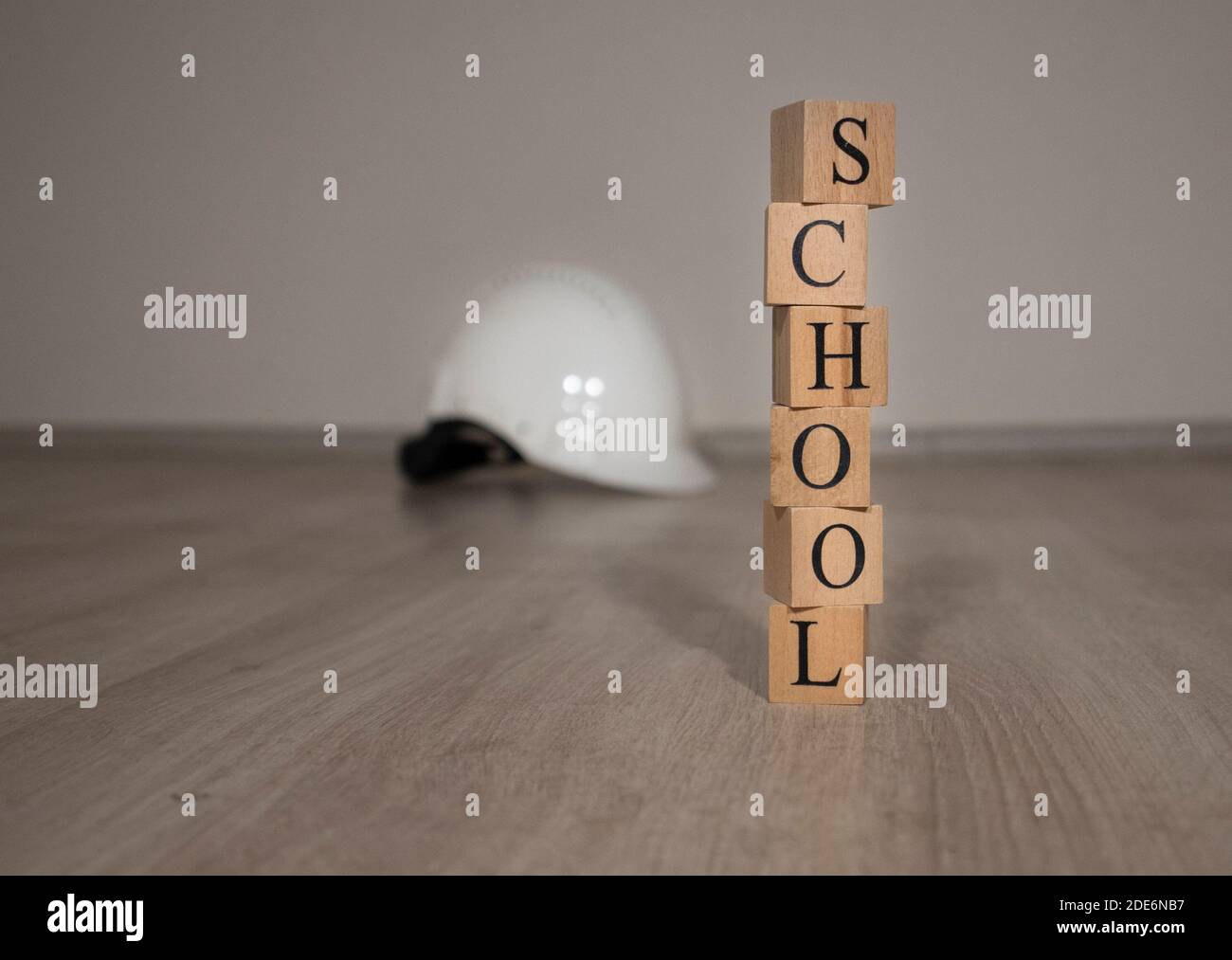 School inscription and hard hat made of wooden cubes. On wooden parquet ...