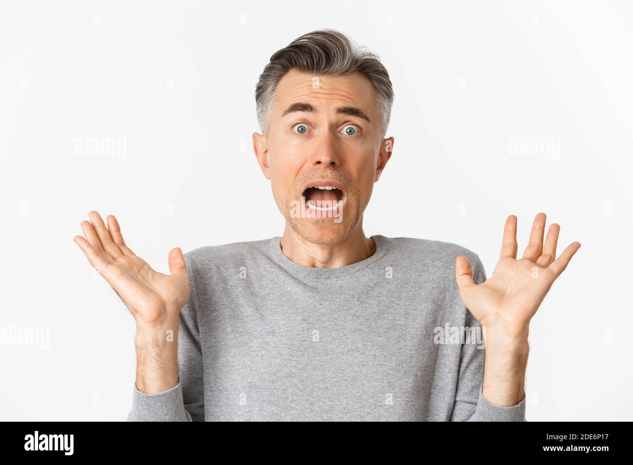 Close-up of scared middle-aged man, looking startled, jumping and ...