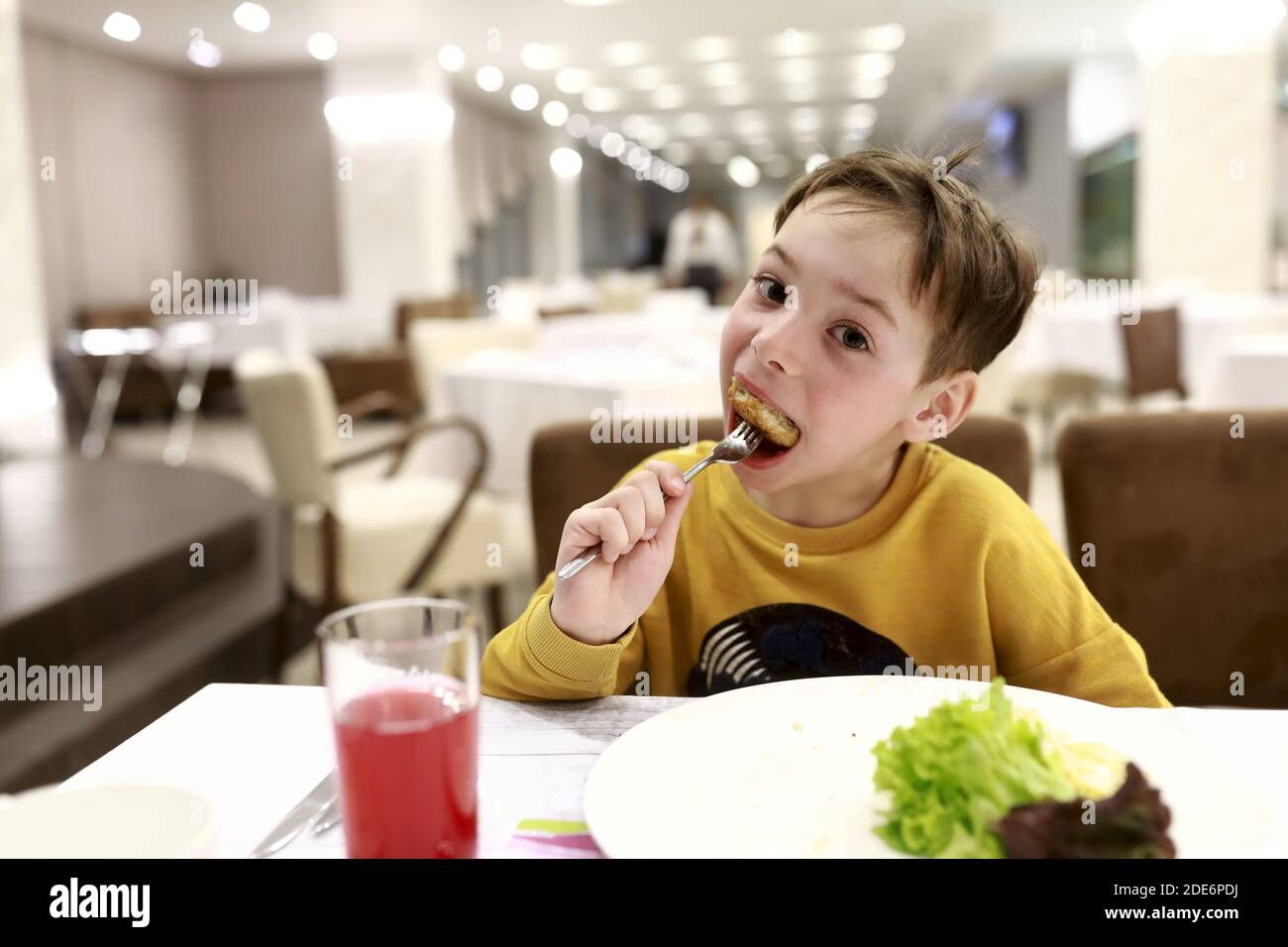 Kid eating chicken cutlet in a restaurant Stock Photo - Alamy