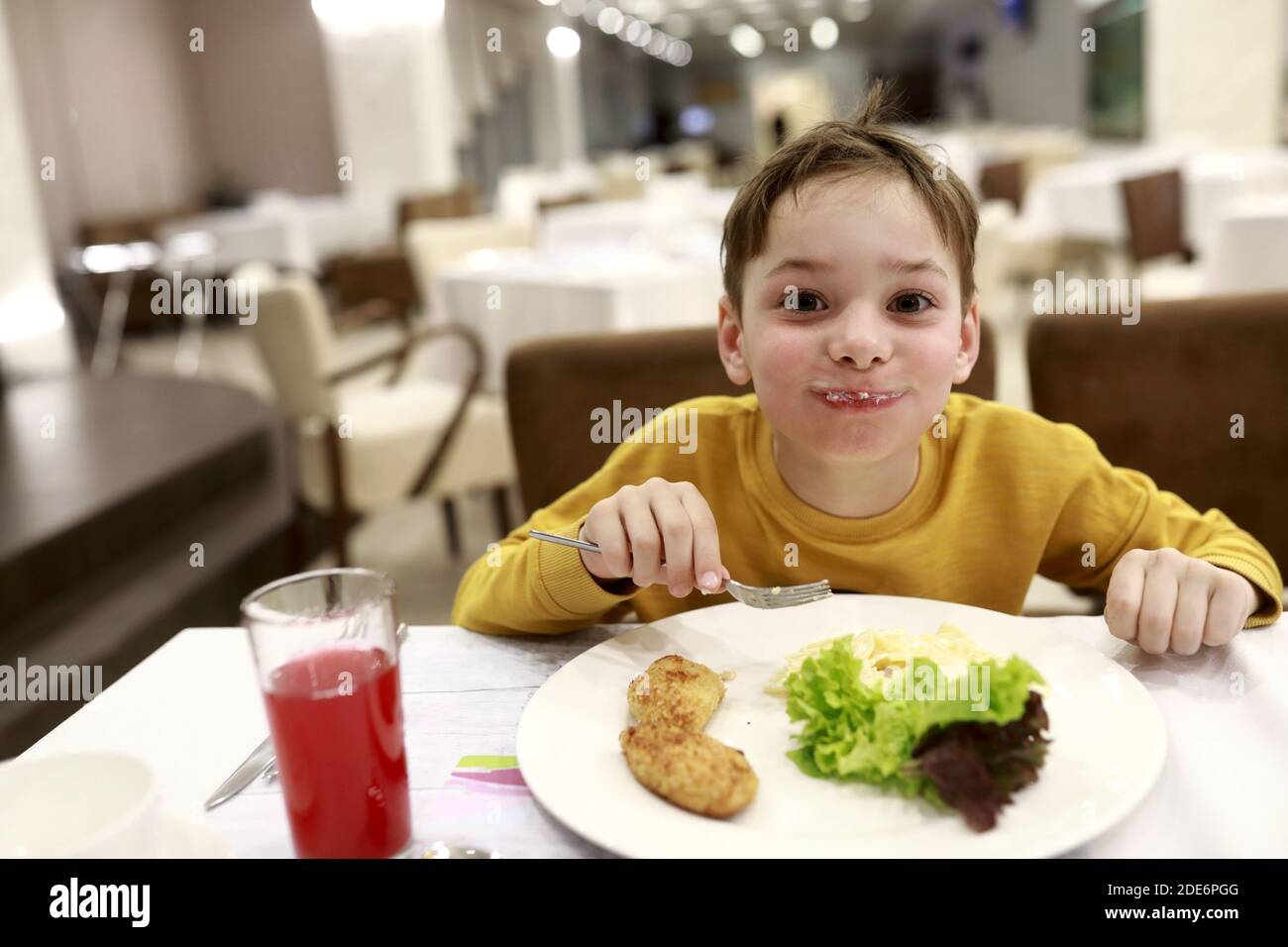 Child eating chicken cutlet in a restaurant Stock Photo - Alamy