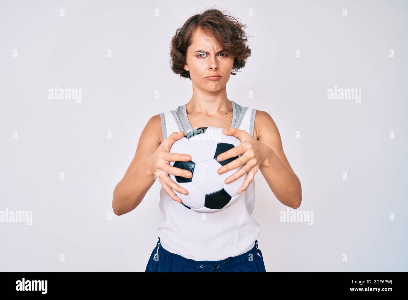 Young hispanic woman holding soccer ball depressed and worry for ...