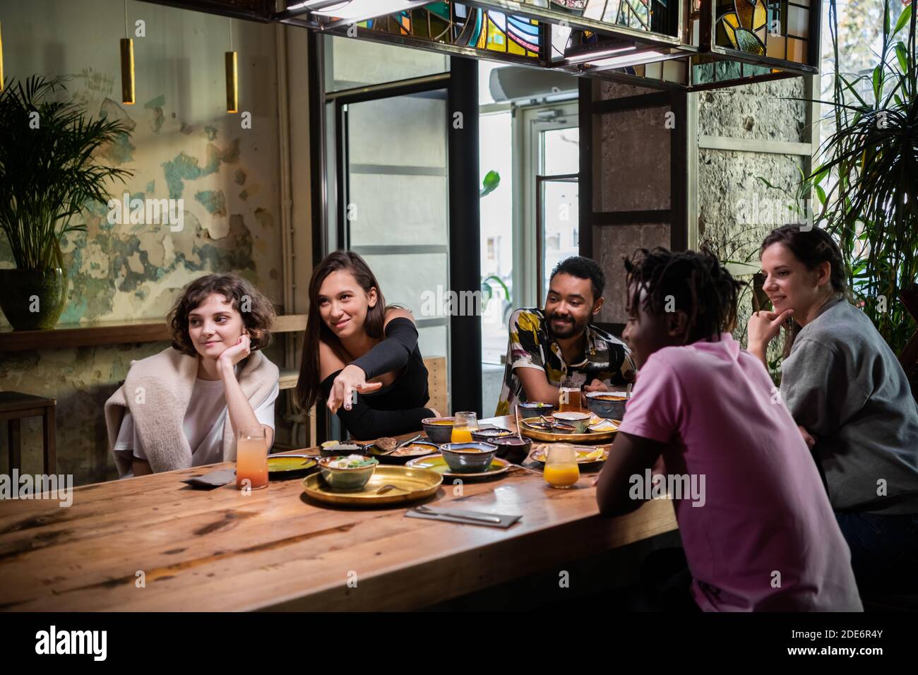 Teenage friends playing charades at the dinner party Stock Photo - Alamy
