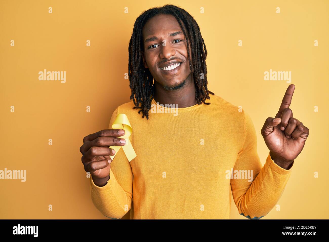 African american man with braids holding suicide prevention yellow ...