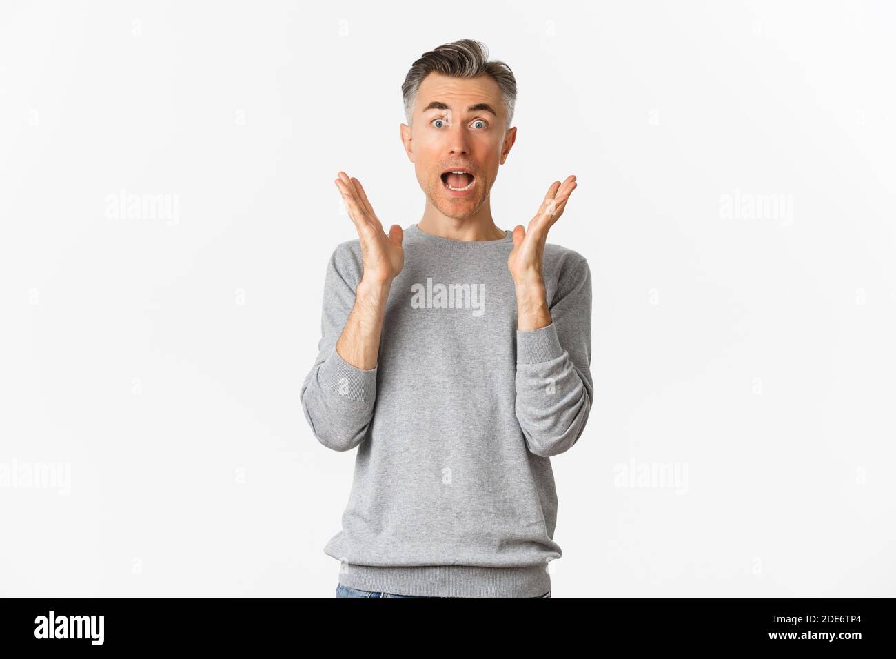 Surprised adult man with gray hair, saying wow and looking amazed ...