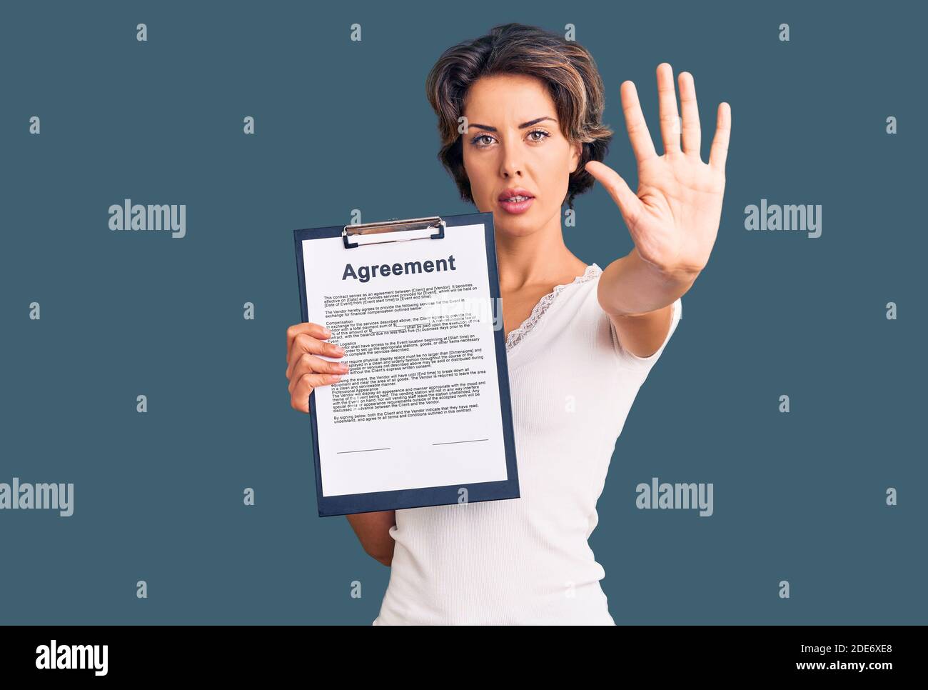 Young beautiful woman holding clipboard with agreement document with ...