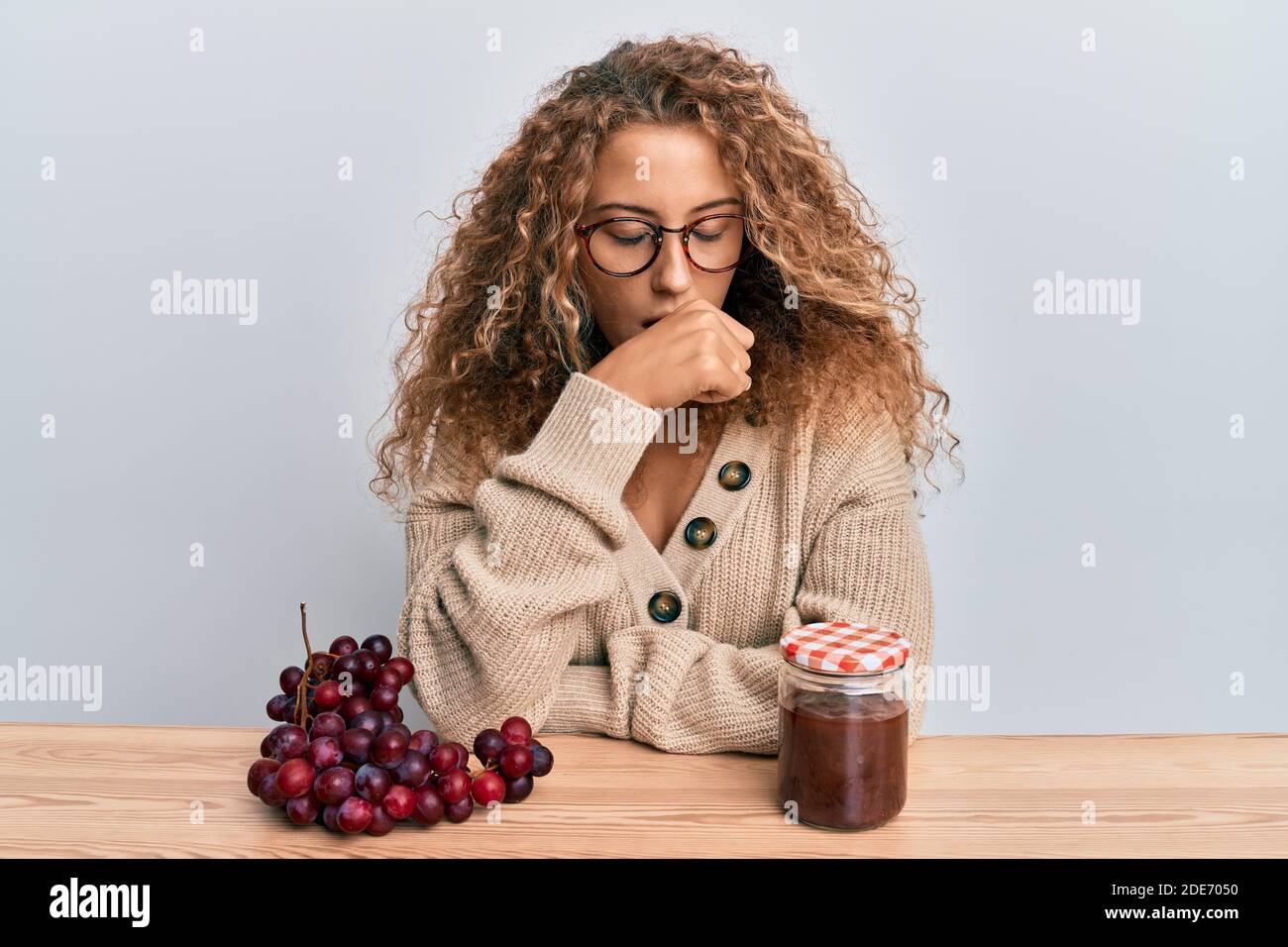 Beautiful caucasian teenager girl making grape jam feeling unwell and ...