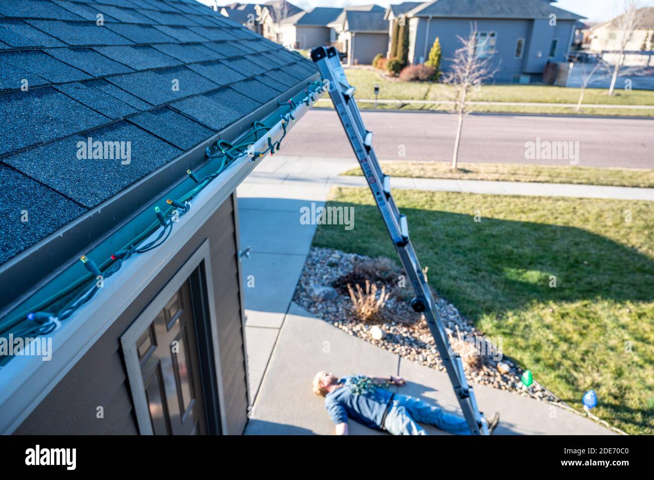 Concept of falling danger involved with hanging Christmas lights on the ...