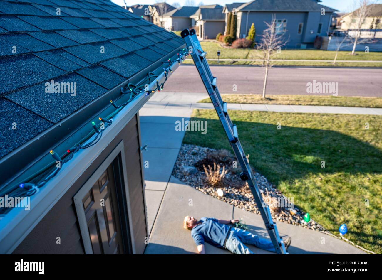 Concept of falling danger involved with hanging Christmas lights on the ...