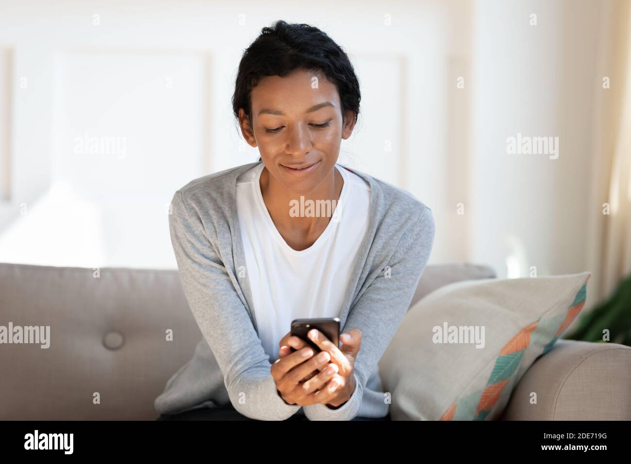 Millennial African American woman use smartphone at home Stock Photo ...