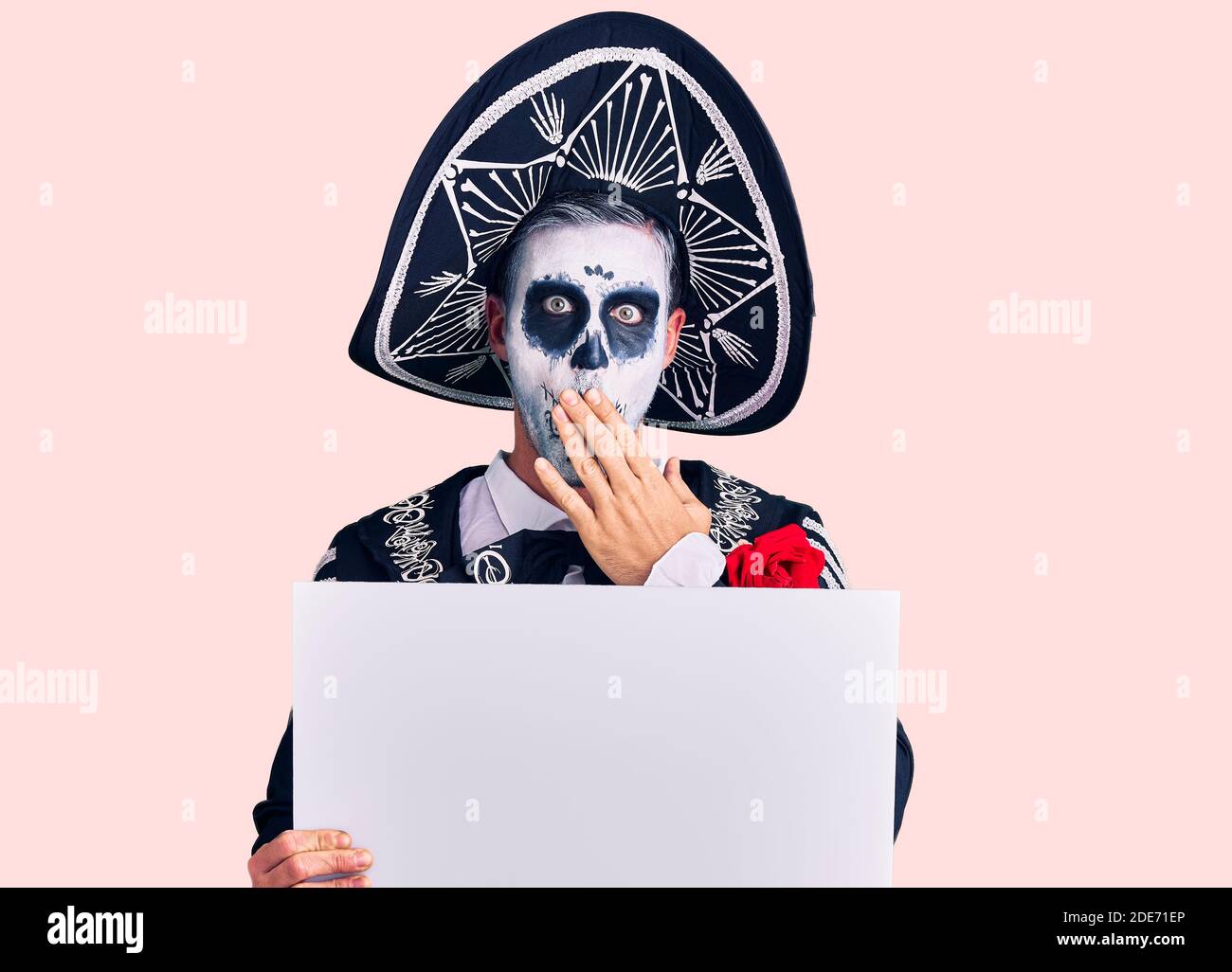 Young man wearing day of the dead costume holding blank empty banner ...