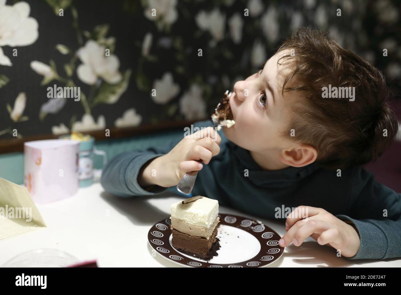 Child eating cake at table in cafe Stock Photo - Alamy