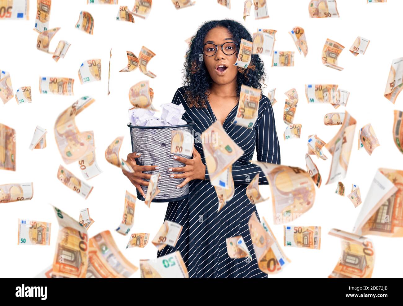 Young african american woman holding paper bin full of crumpled papers ...