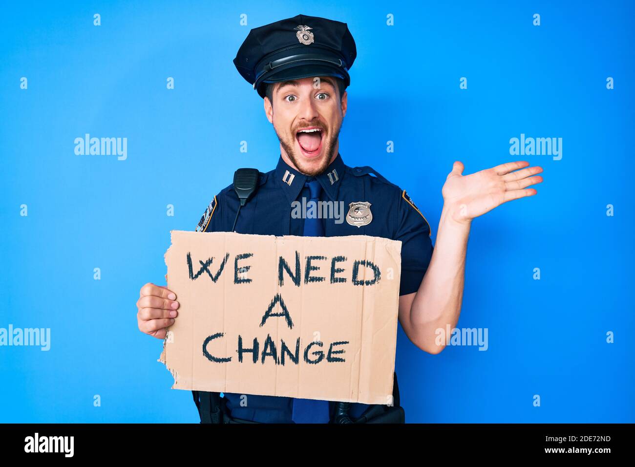 Young caucasian man wearing police uniform holding we need a change ...