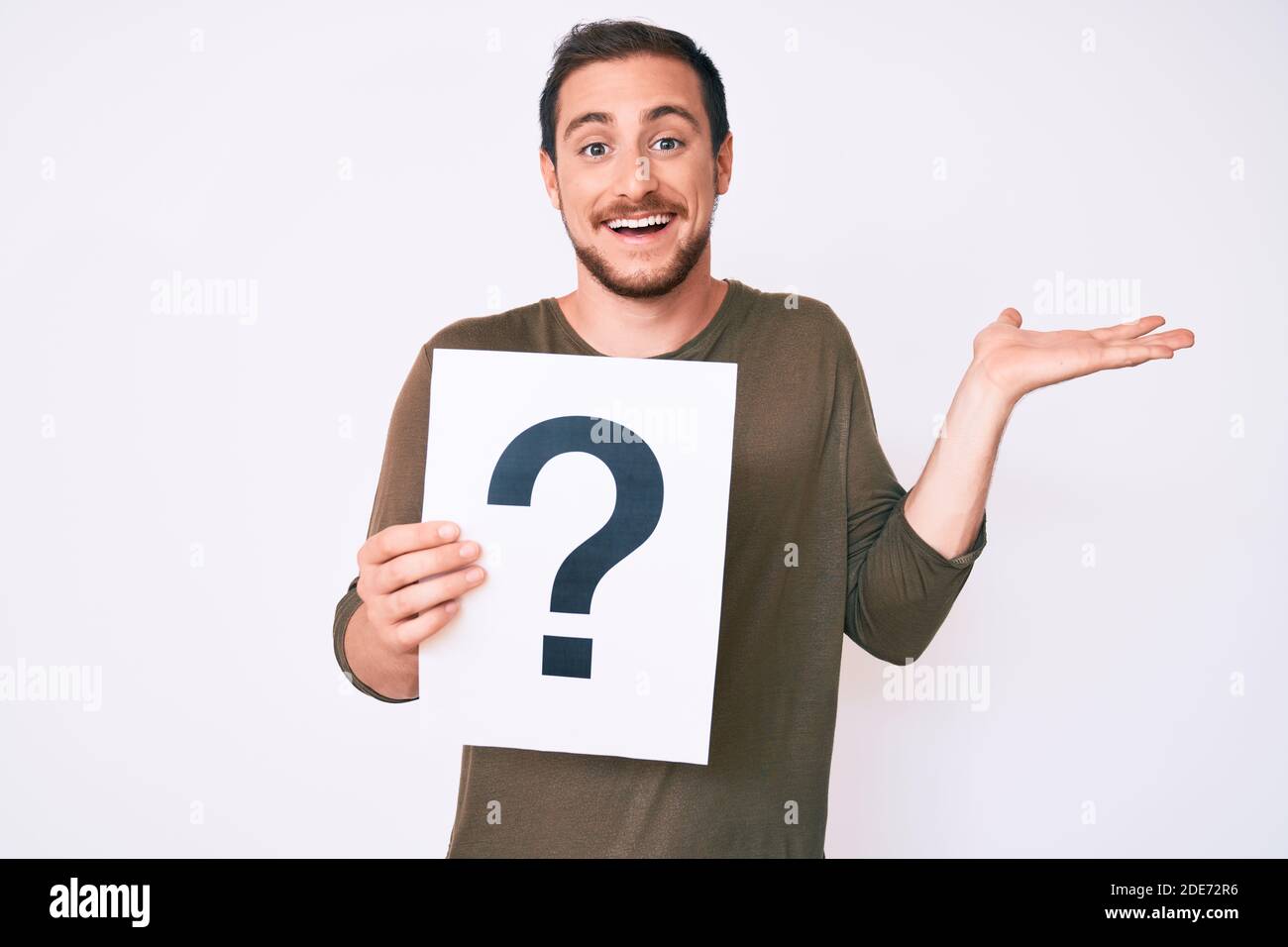 Young handsome man holding question mark celebrating victory with happy ...