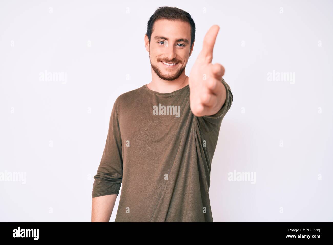 Young handsome man wearing casual clothes smiling friendly offering ...