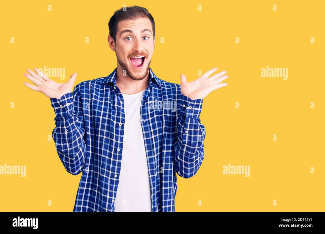 Young handsome caucasian man wearing casual clothes celebrating crazy ...
