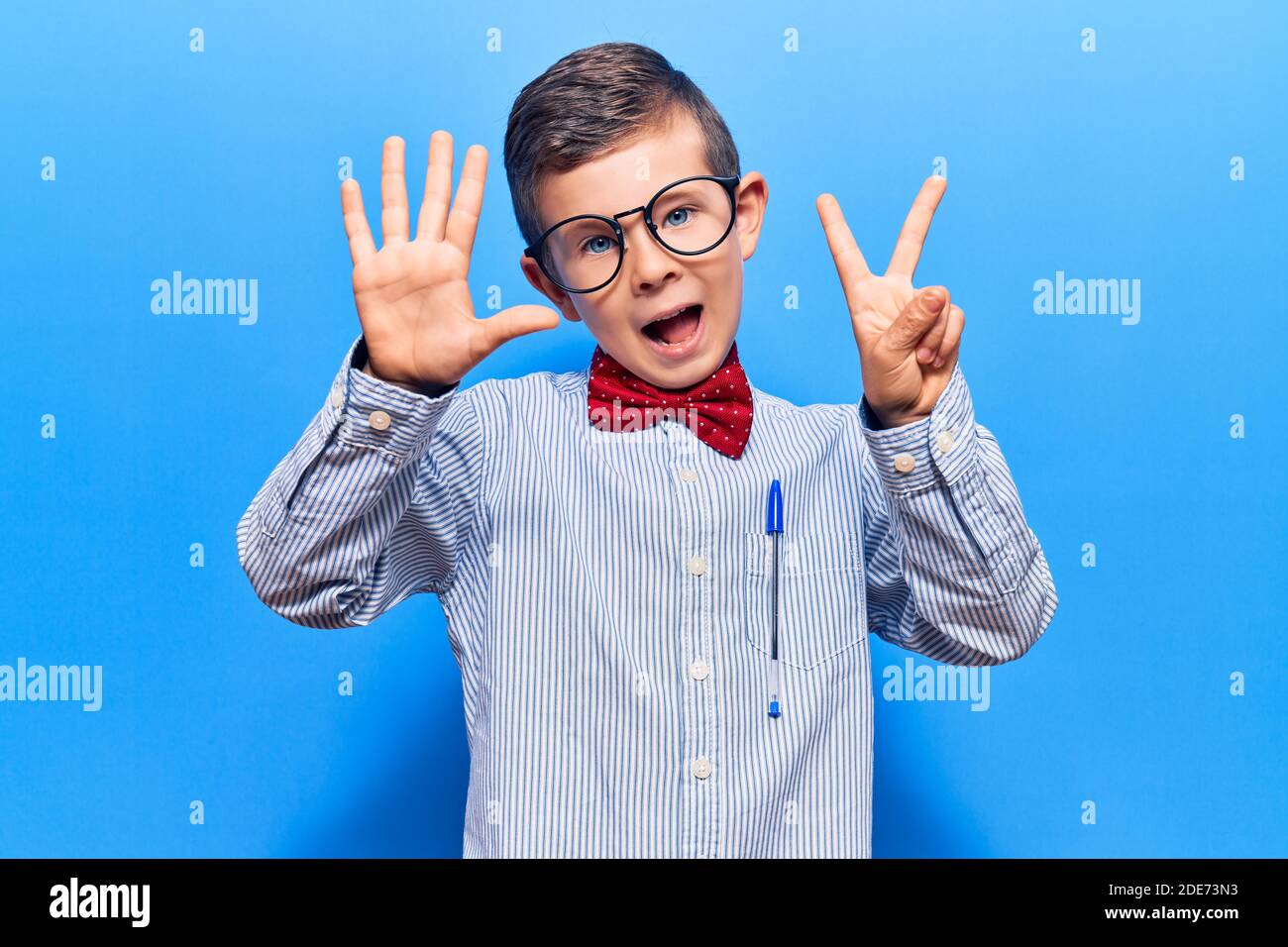 Cute blond kid wearing nerd bow tie and glasses showing and pointing up ...