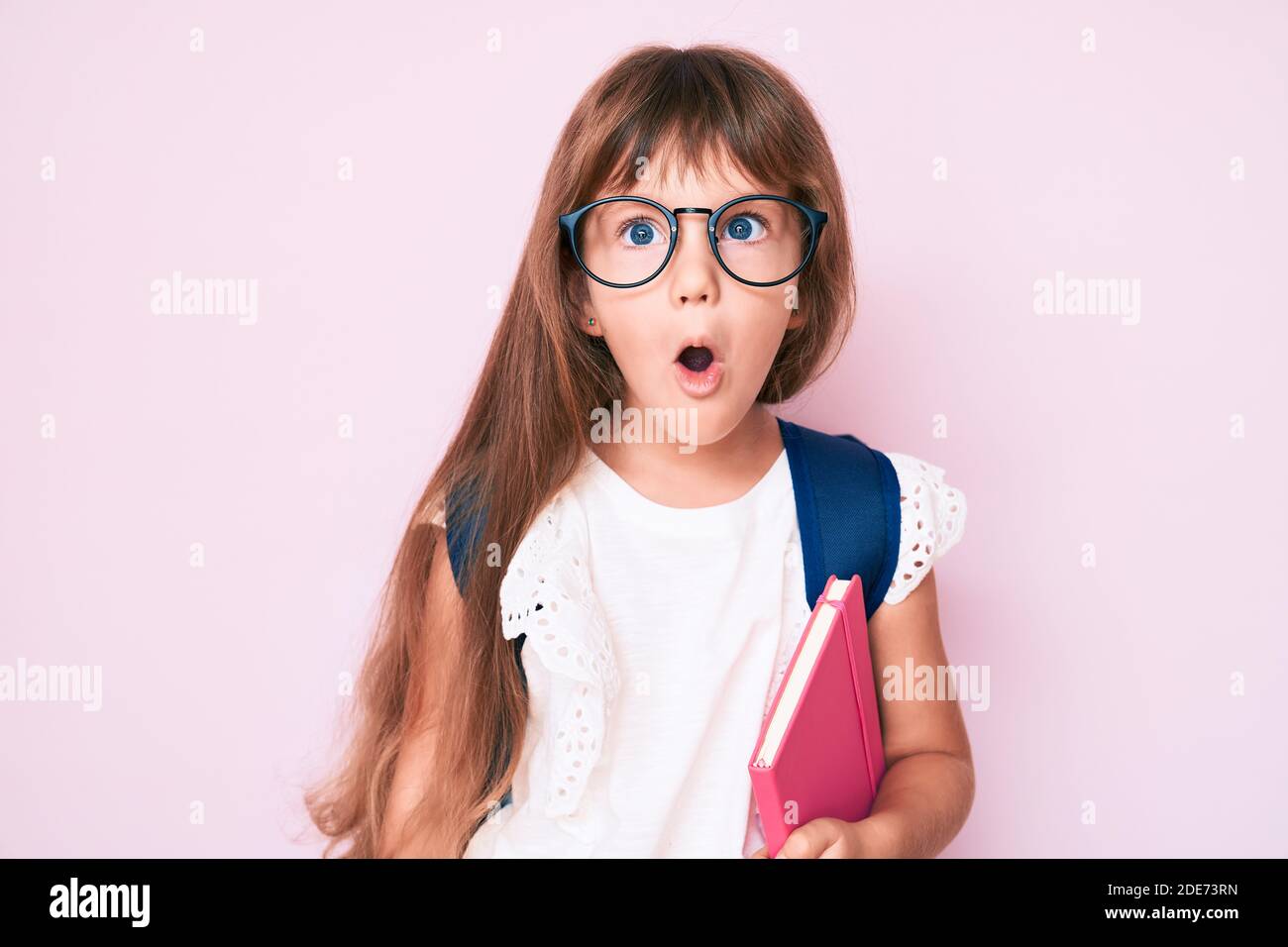 Little caucasian kid girl with long hair wearing student backpack and ...