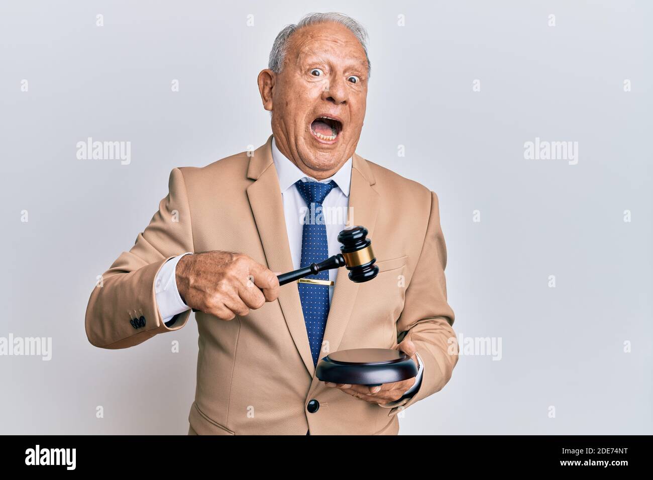 Senior caucasian judge man using gavel celebrating crazy and amazed for ...