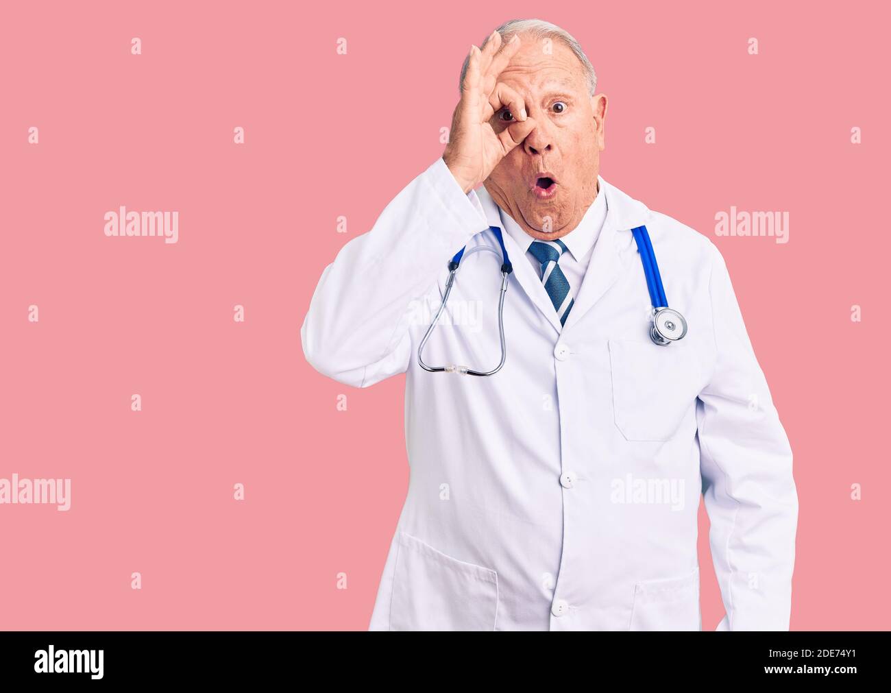 Senior handsome grey-haired man wearing doctor coat and stethoscope ...