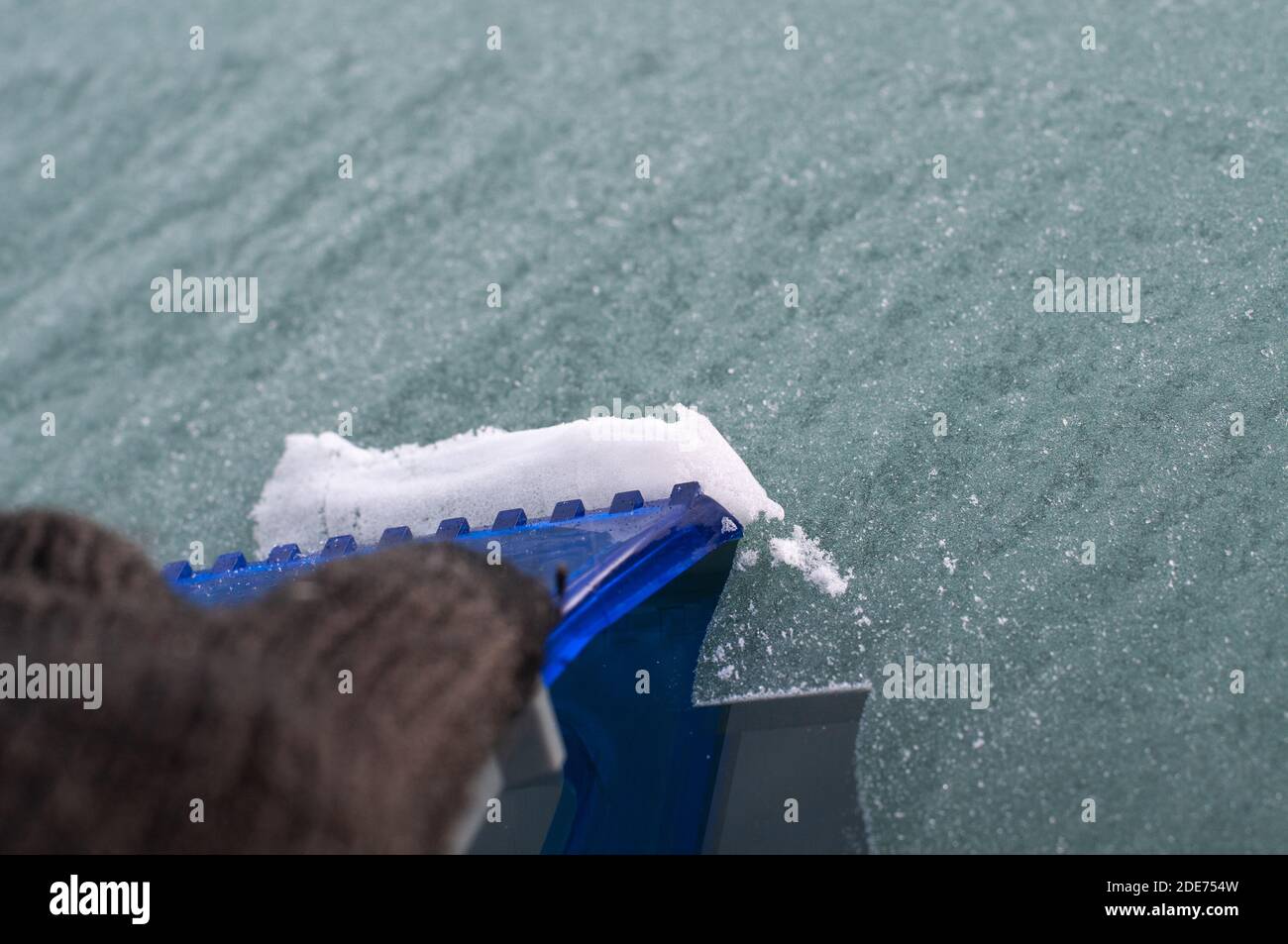 scratching ice from a windshield of a car on a frosty morning Stock ...