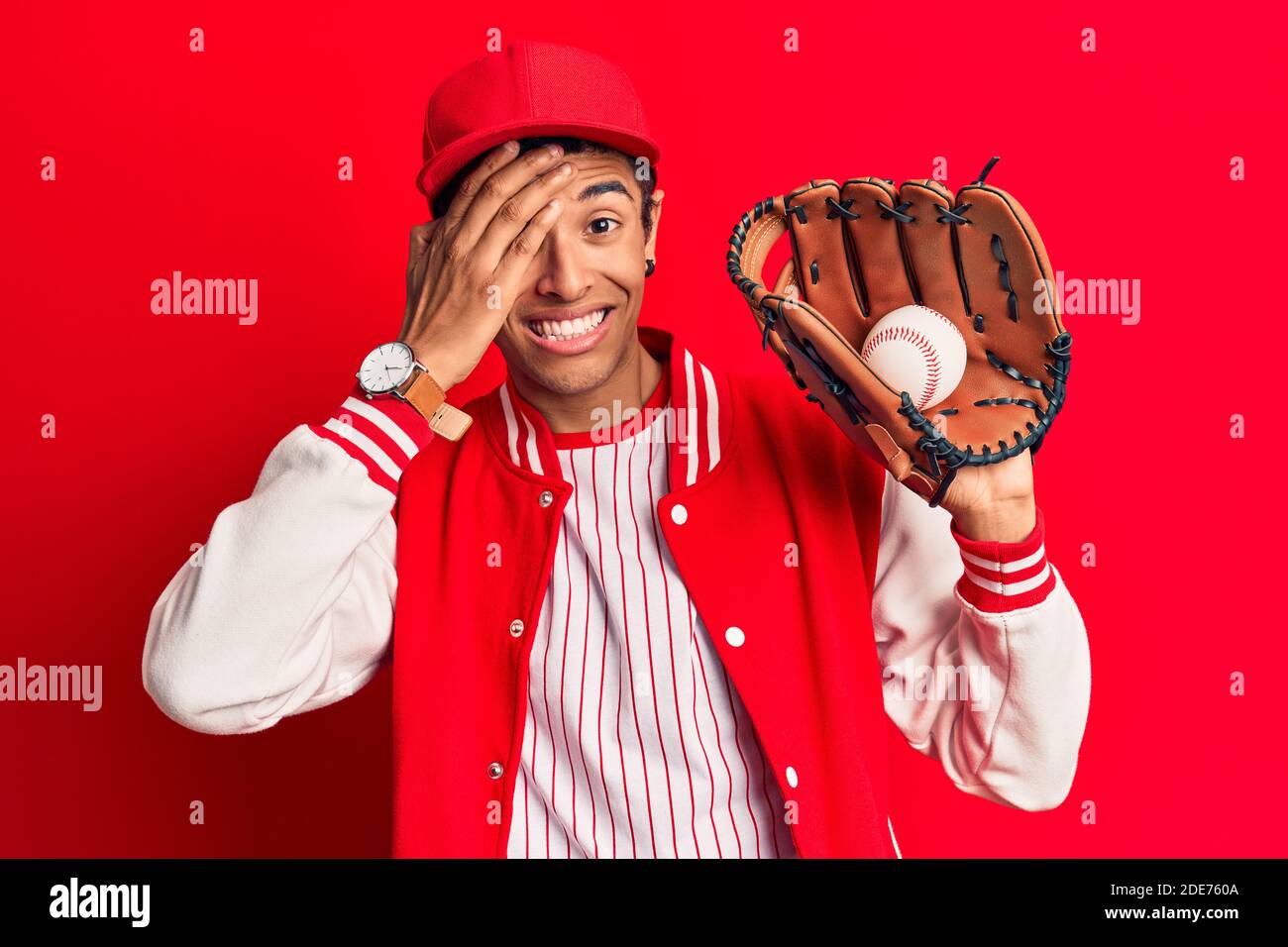 Young african amercian man wearing baseball uniform holding golve and ...