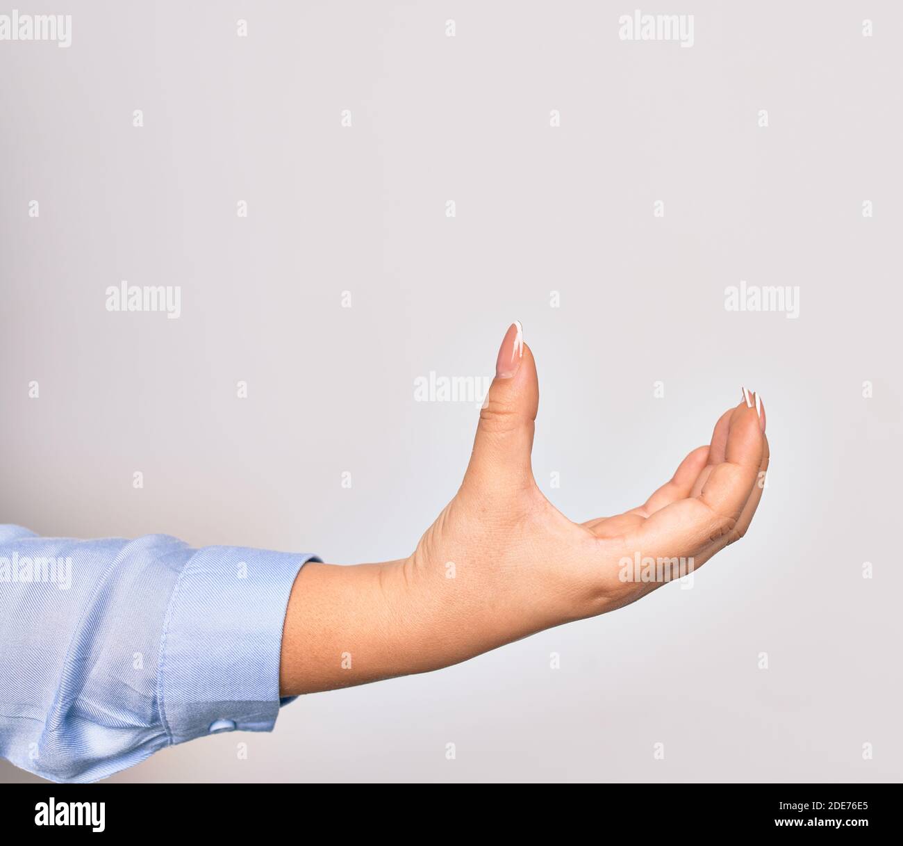 Hand of caucasian young woman doing catch sign over isolated white ...