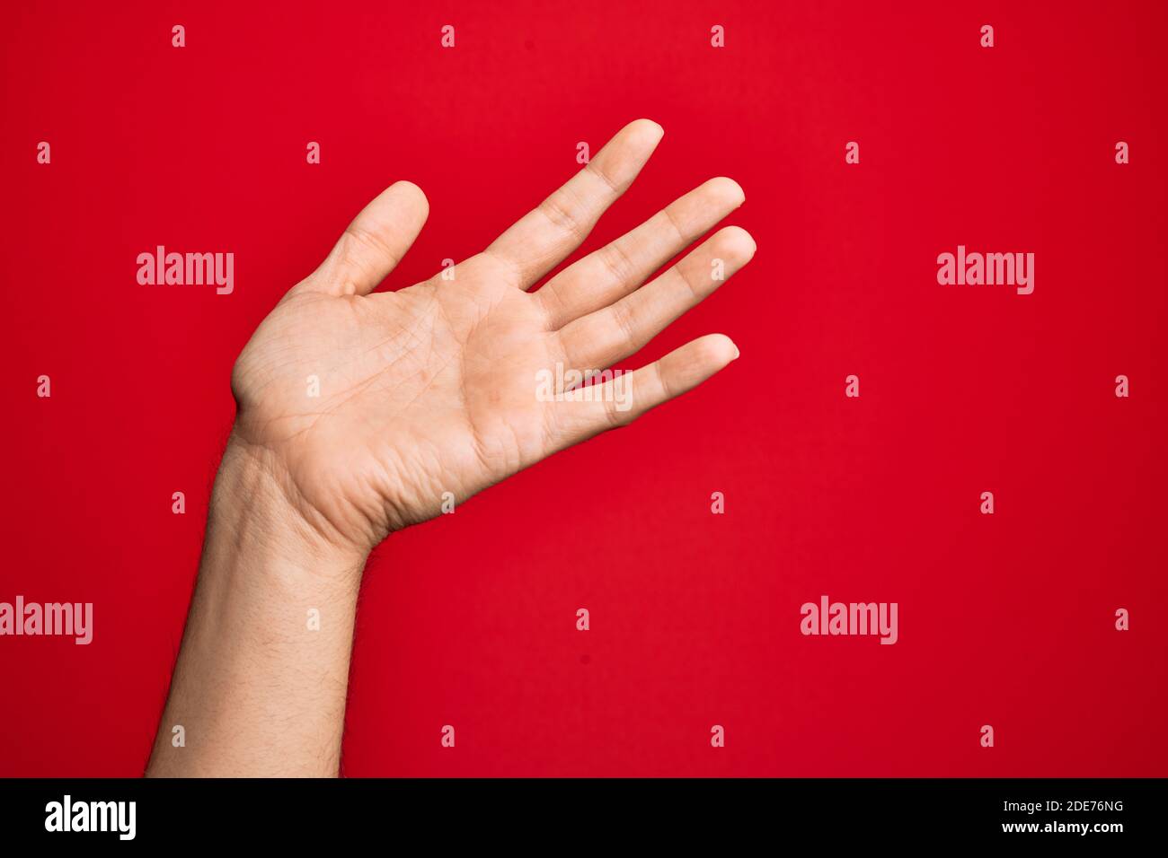 Hand of caucasian young man showing fingers over isolated red ...