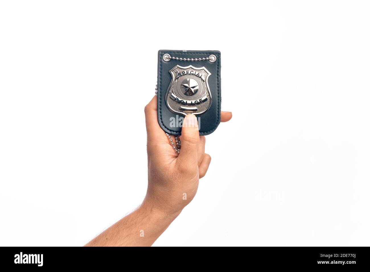 Hand of caucasian young man holding police badge over isolated white ...