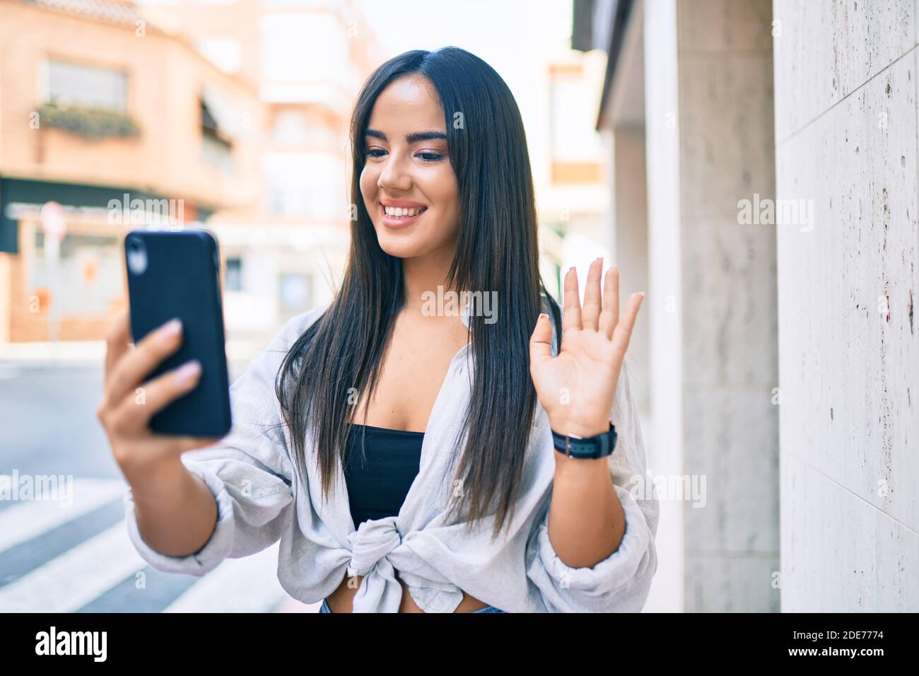 Young hispanic girl smiling happy doing video call using smartphone at the city Stock Photo - Alamy