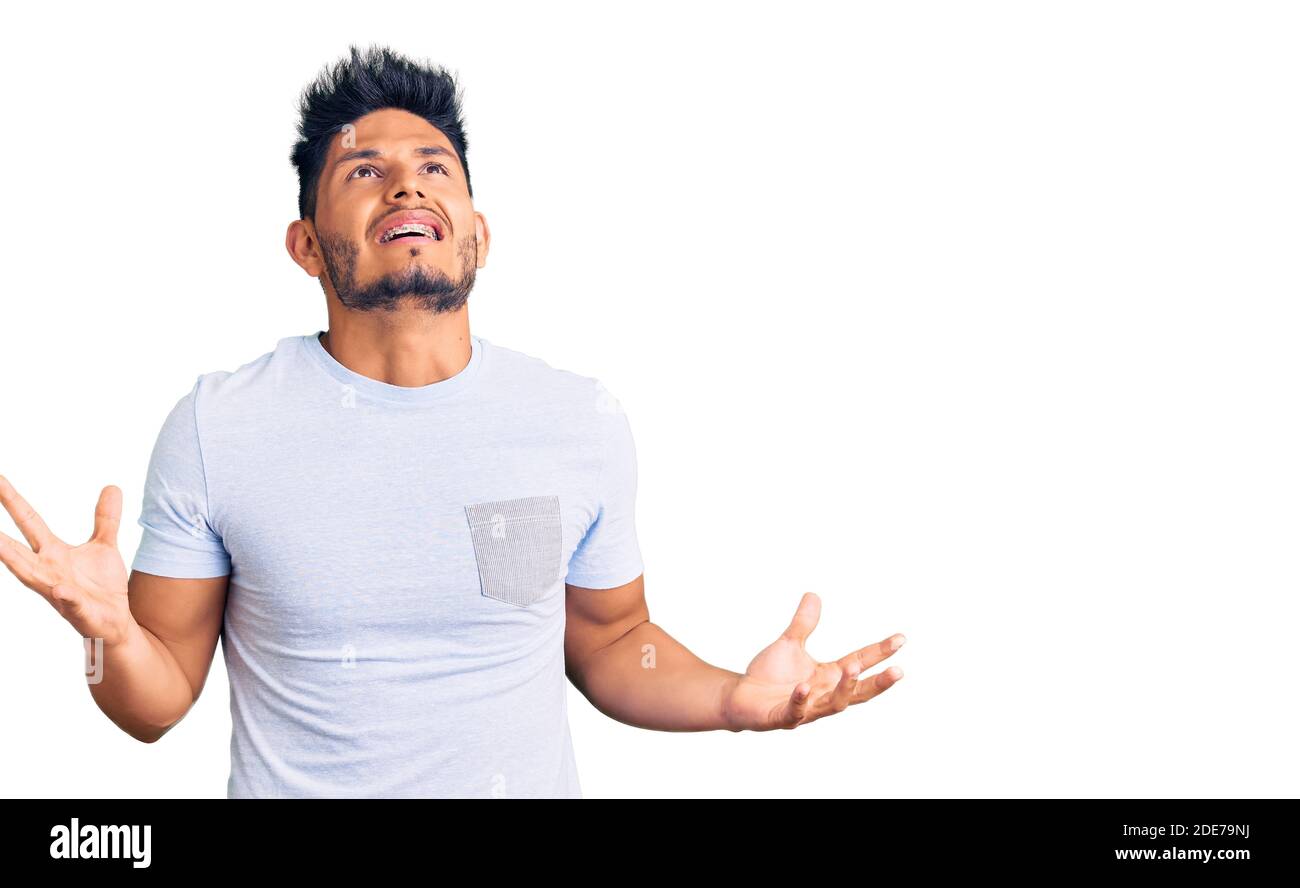 Handsome latin american young man wearing casual clothes crazy and mad ...