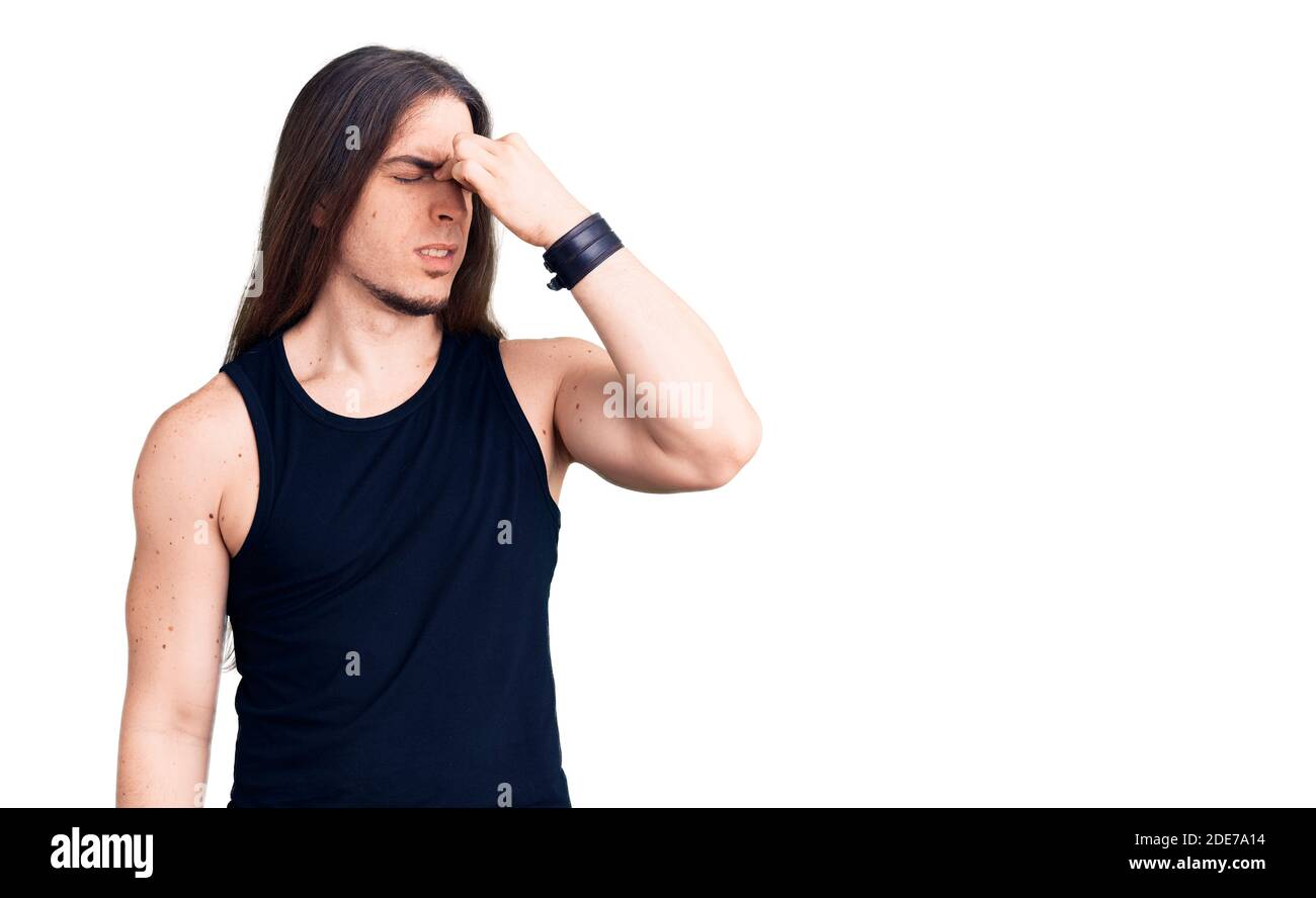 Young adult man with long hair wearing goth style with black clothes ...