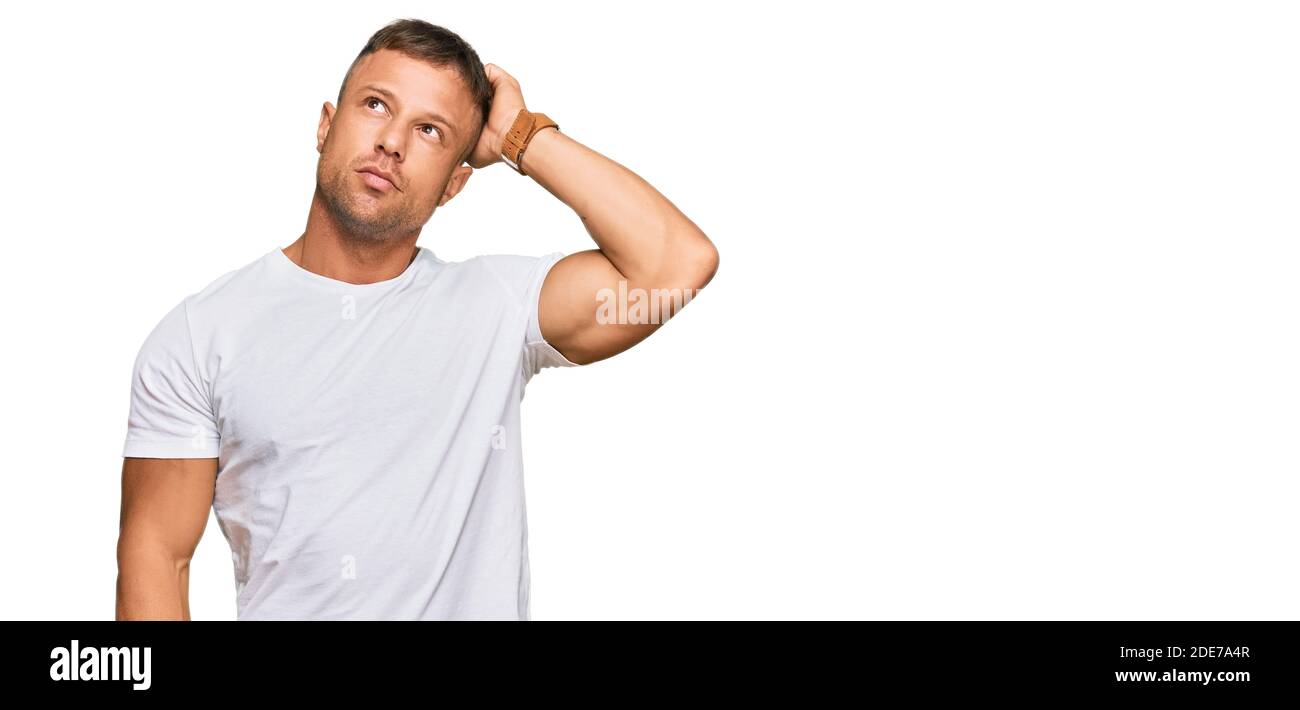 Handsome muscle man wearing casual white tshirt confuse and wondering ...