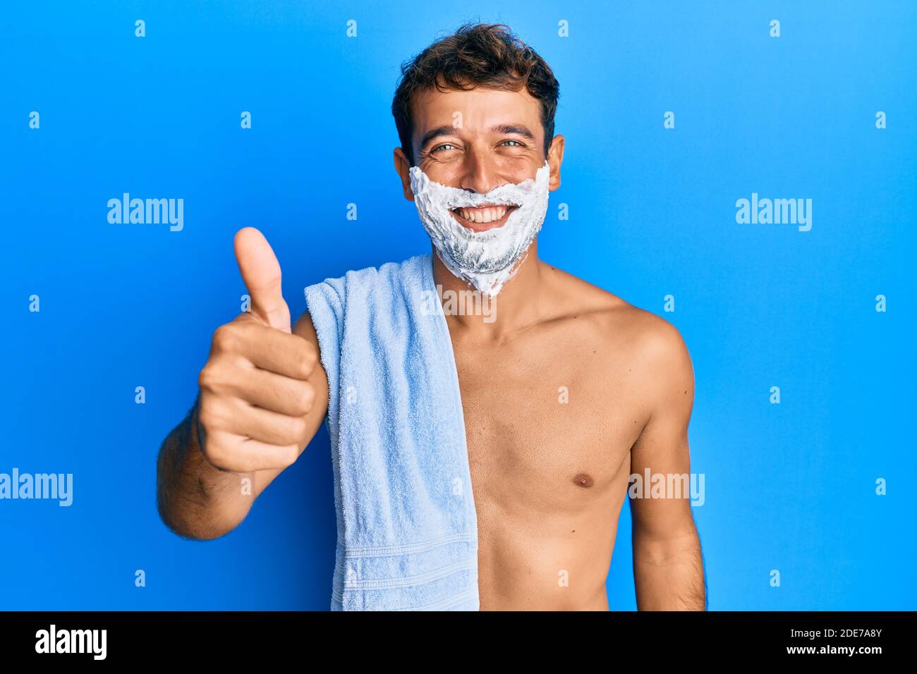 Handsome man saving beard with shave foam over face smiling happy and ...