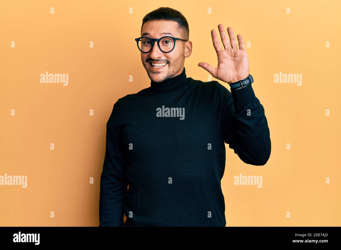 Handsome man with tattoos wearing turtleneck sweater and glasses ...