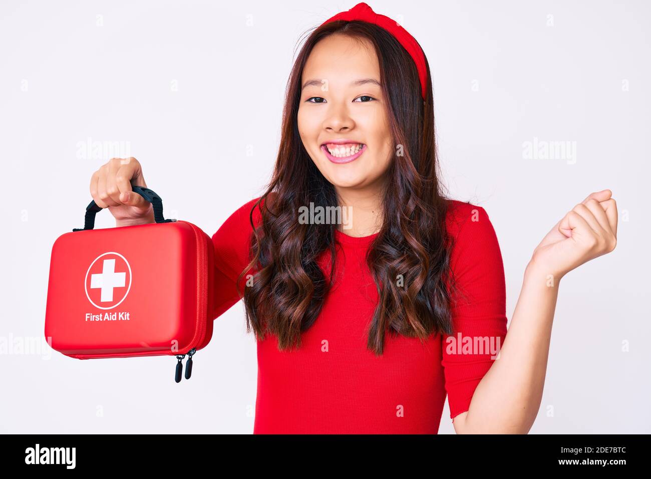 Young beautiful chinese girl holding first aid kit screaming proud ...