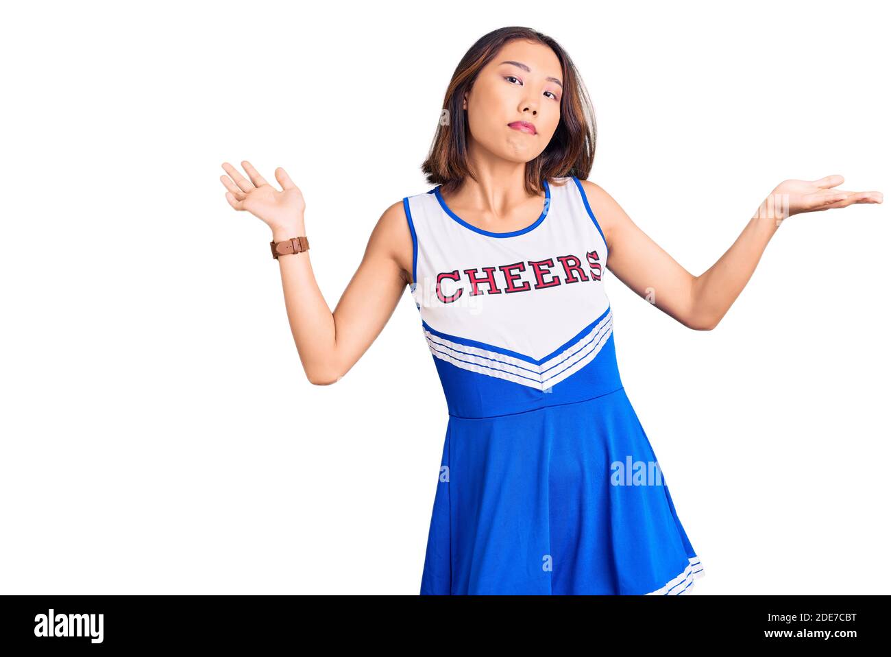 Young beautiful chinese girl wearing cheerleader uniform clueless and ...