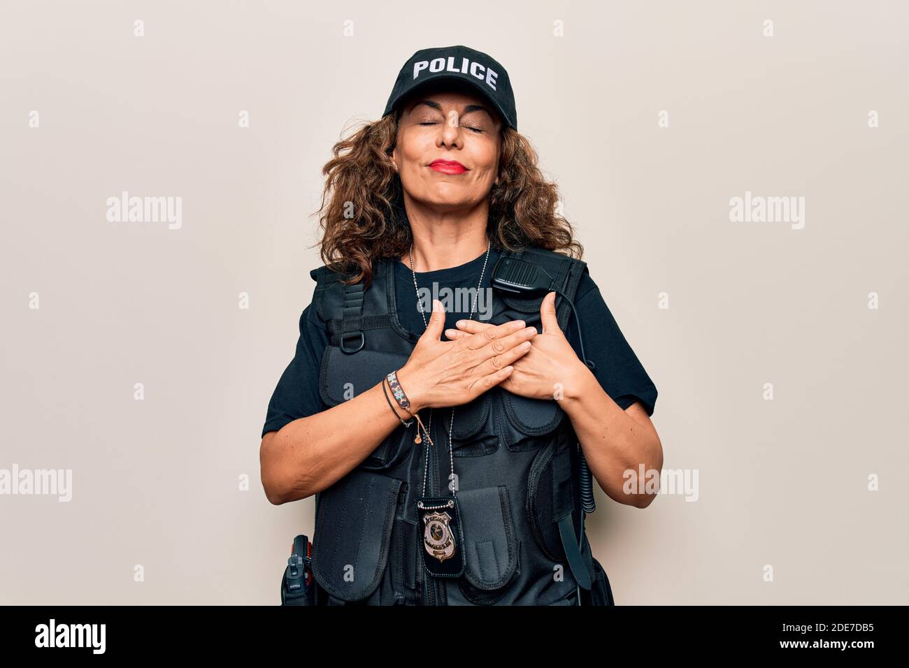 Middle age beautiful policewoman wearing bulletproof uniform and cap ...