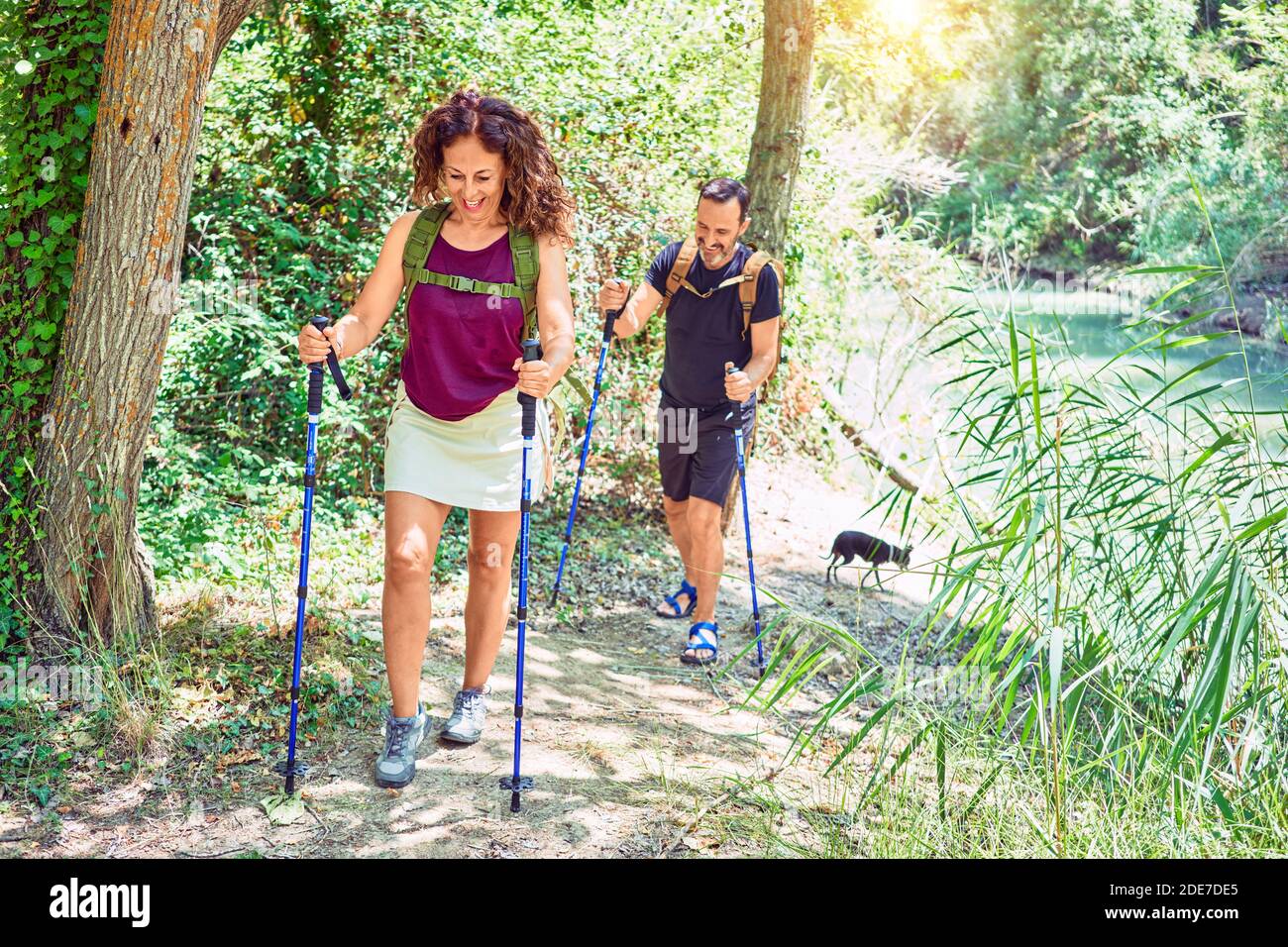 Beautiful couple of hiker wearing backpack smiling happy. Standing with ...