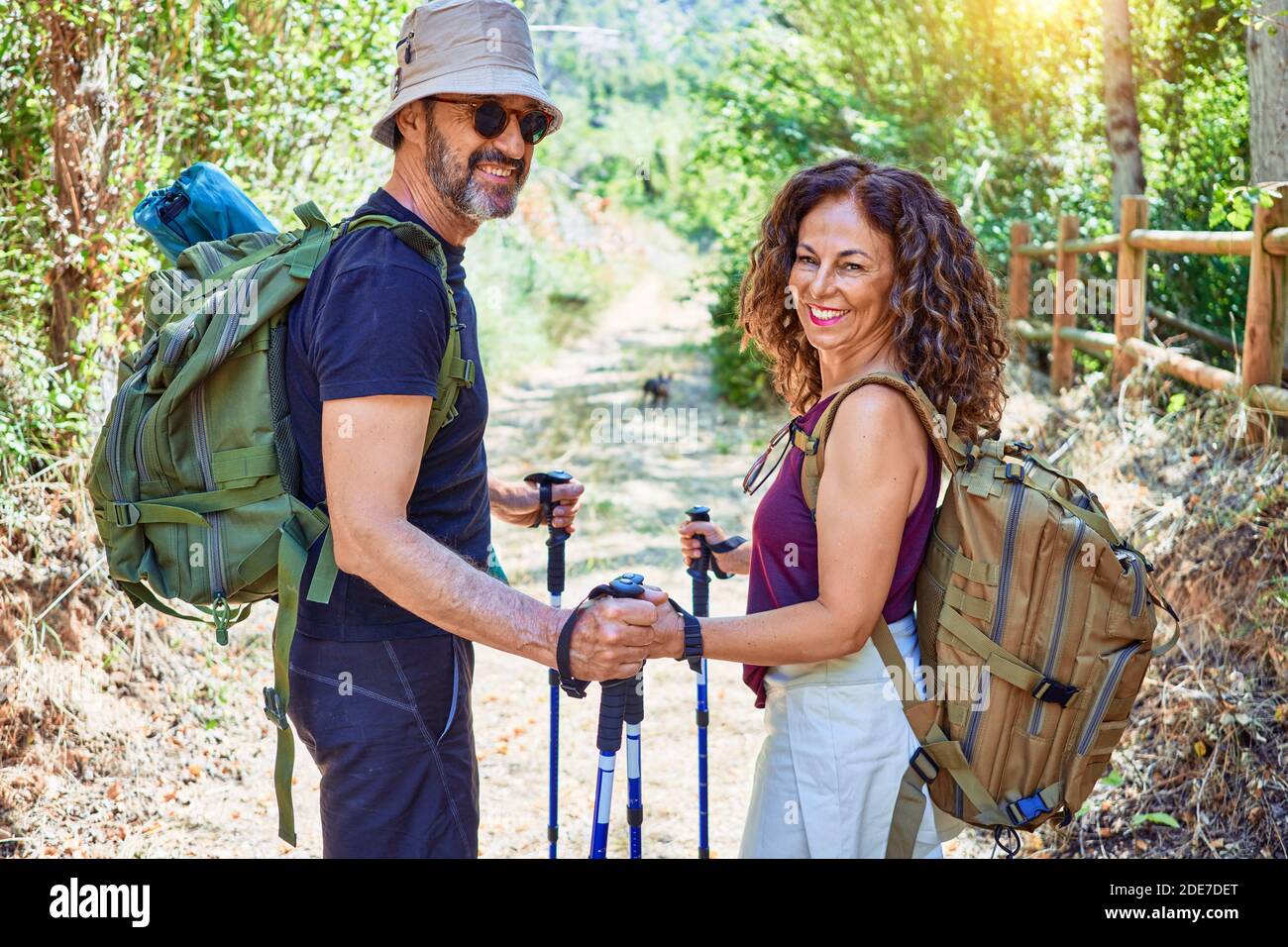 Beautiful couple of hiker wearing backpack smiling happy. Standing with ...