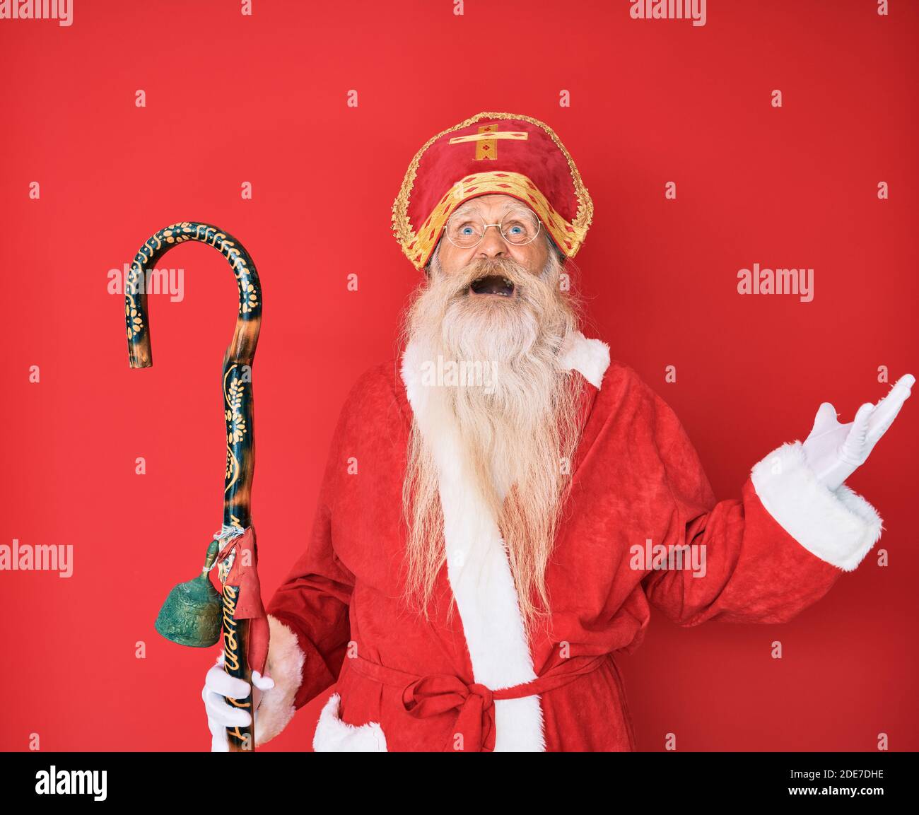 Old senior man with grey hair and long beard wearing traditional saint ...